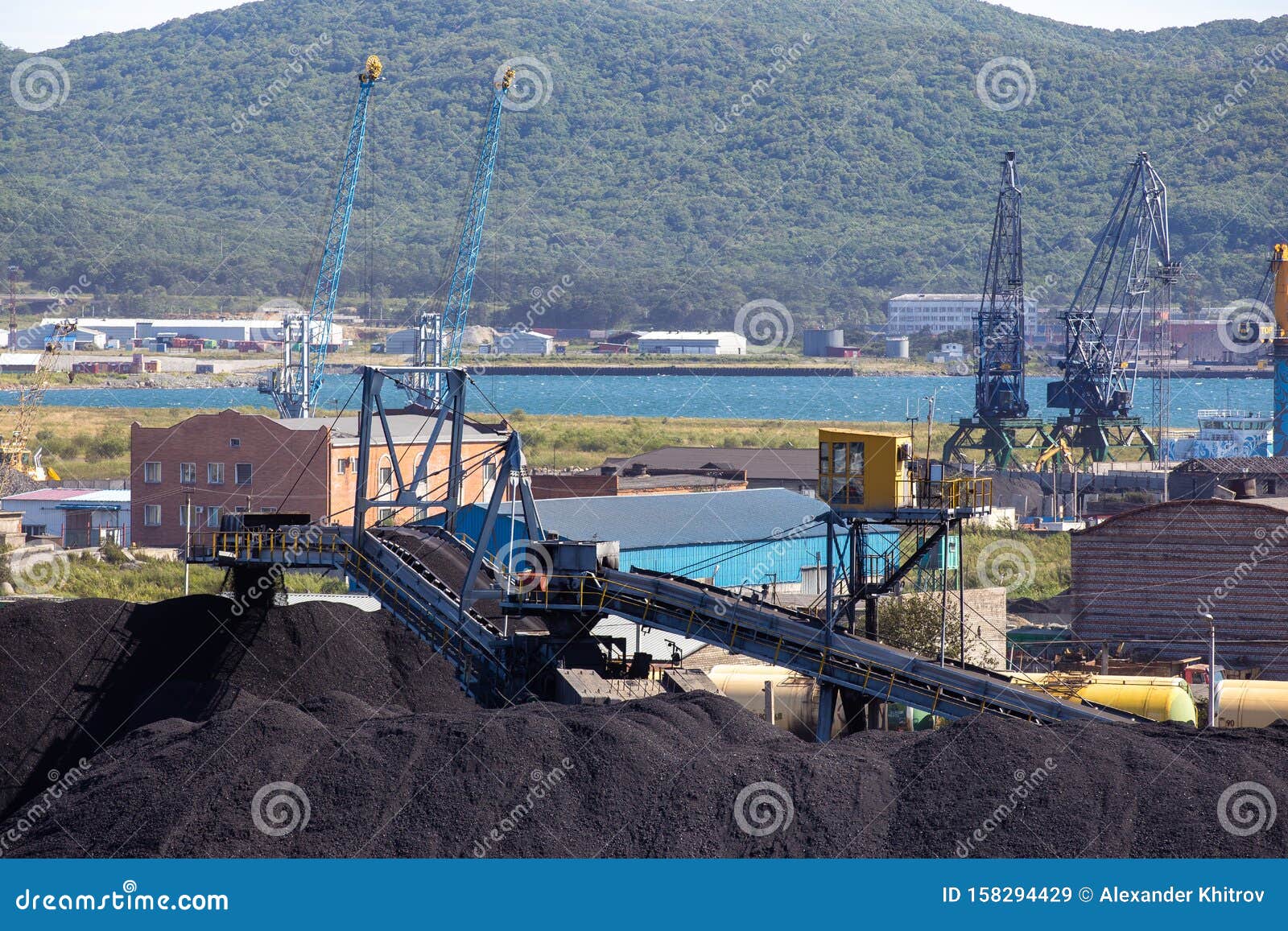 Stacker-reclaimer during Loading and Unloading of Coal. Coal Heaps at a ...