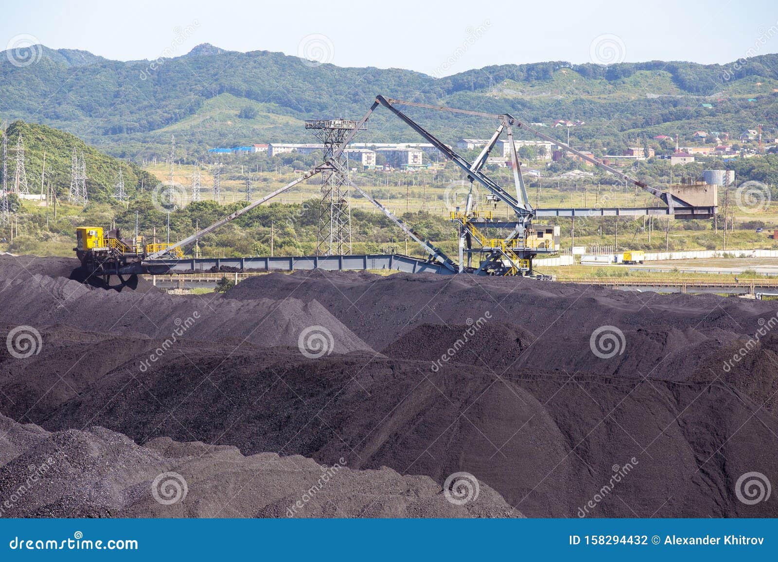 Stacker-reclaimer during Loading and Unloading of Coal. Coal Heaps at a ...