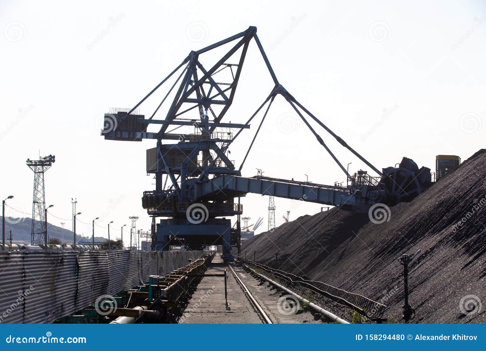 Stacker-reclaimer during Loading and Unloading of Coal. Coal Heaps at a ...