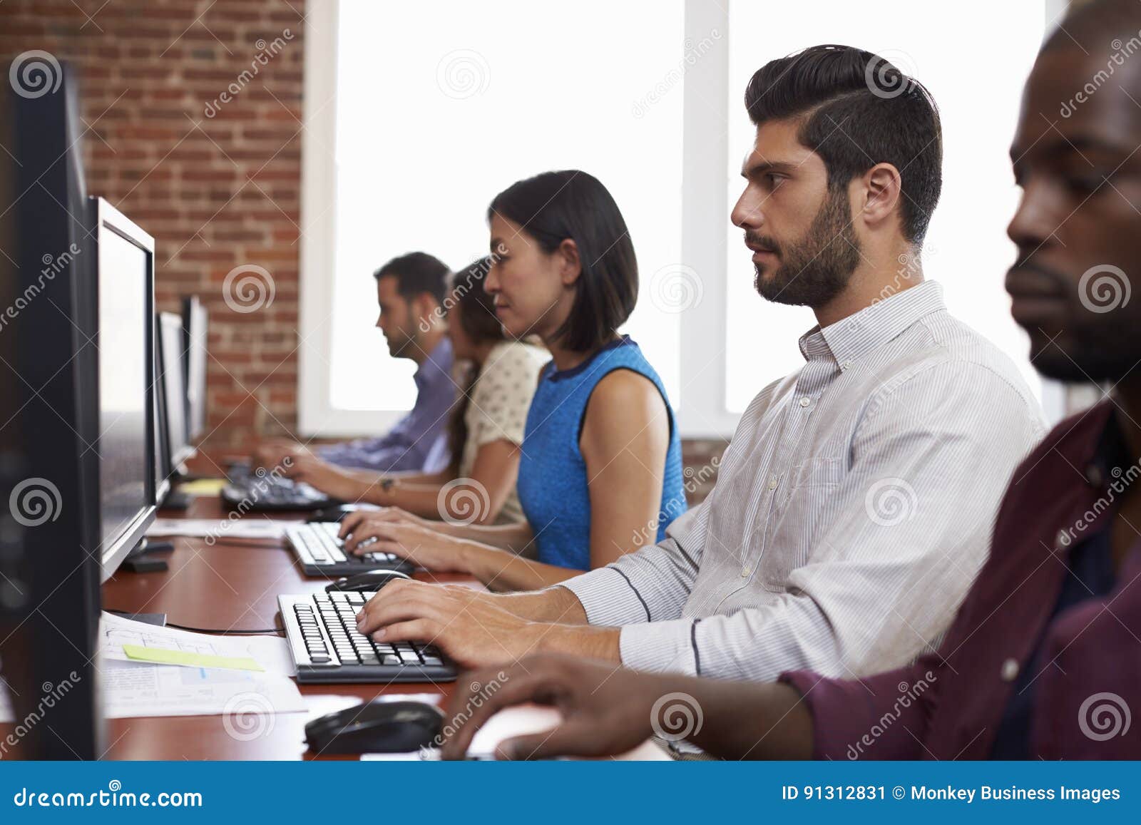 Staff Sitting at Desks Using Computers in Busy Office Stock Image ...