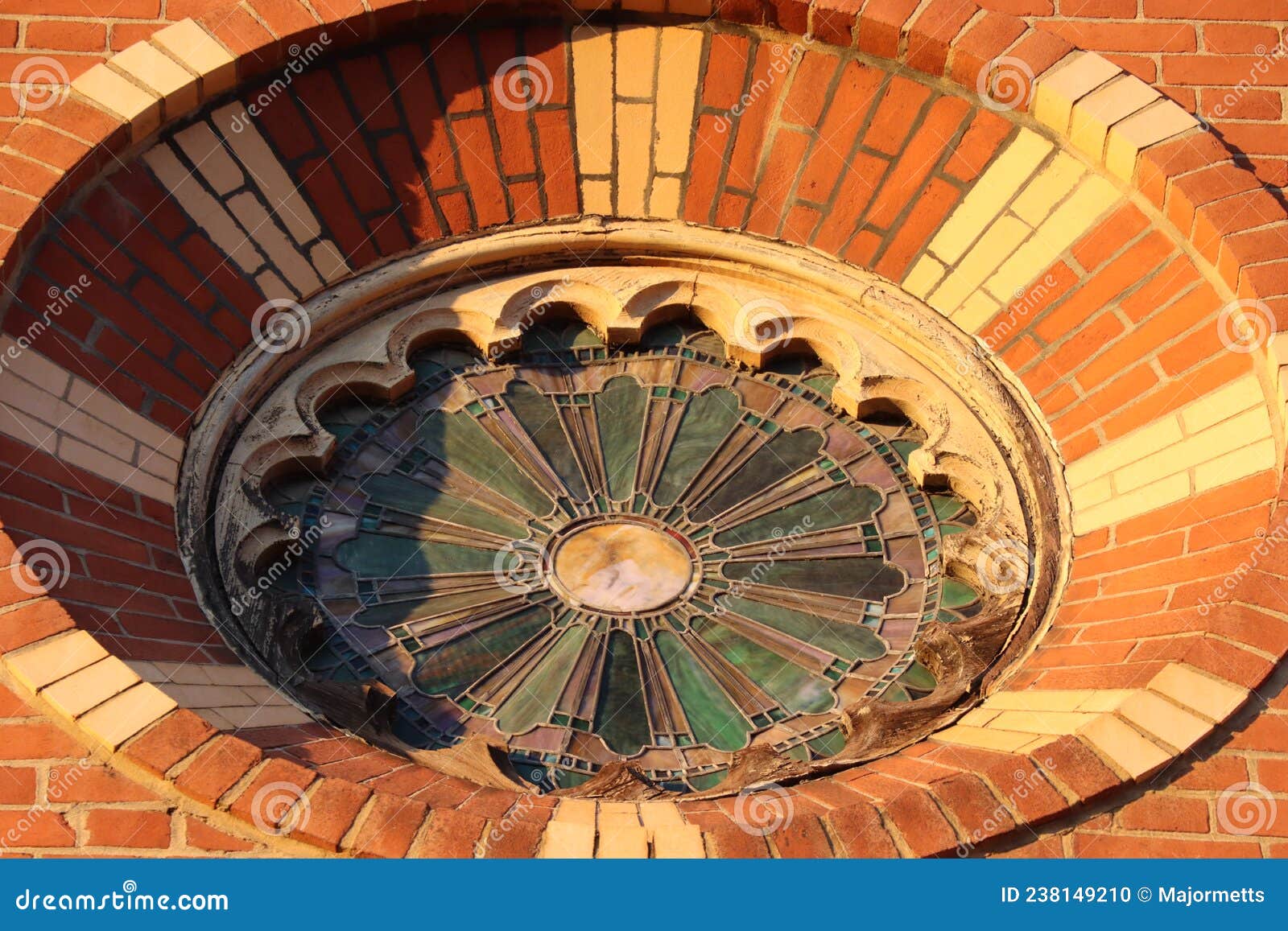 Stained Glass Round Window Surrounded by Red and Cream Brick ...