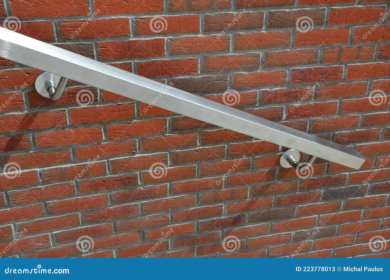 A Stainless Steel Handrail Handle is Attached To the Wall. the Wall is ...