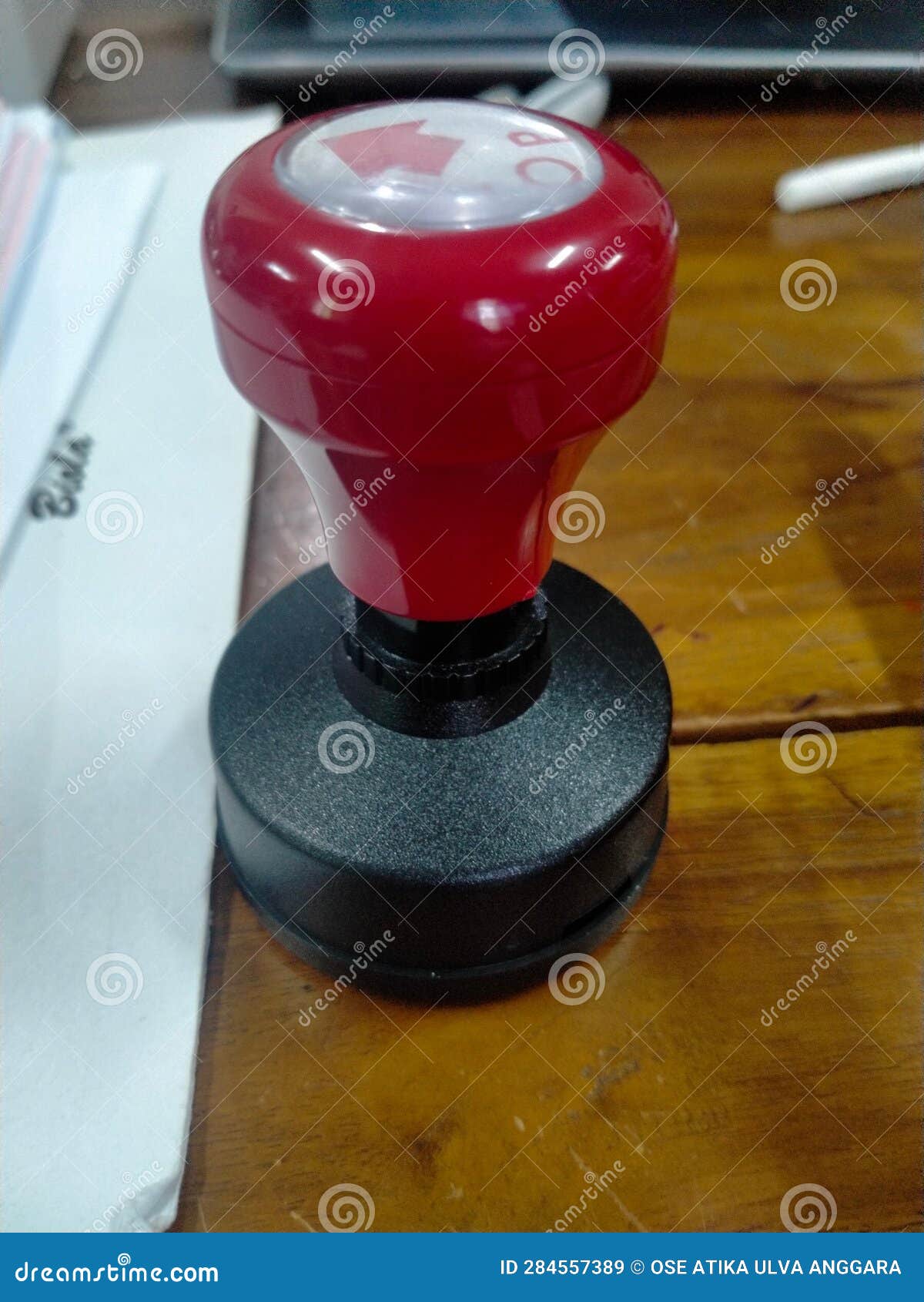 A Stample in the Shape of a Circle with a Red Body on Top and Black on ...