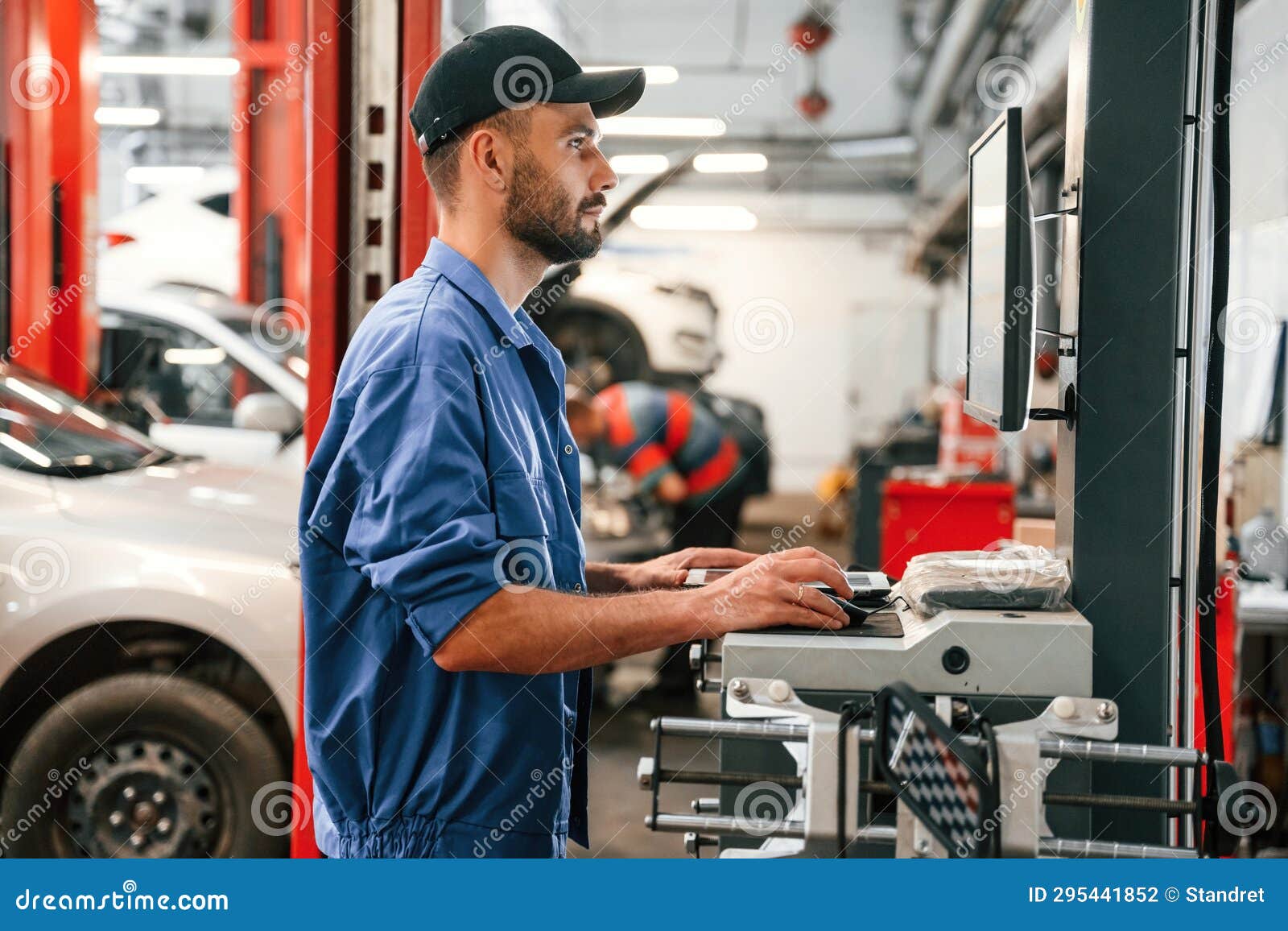 Standing by Computer Terminal. Auto Mechanic Working in Garage Stock ...