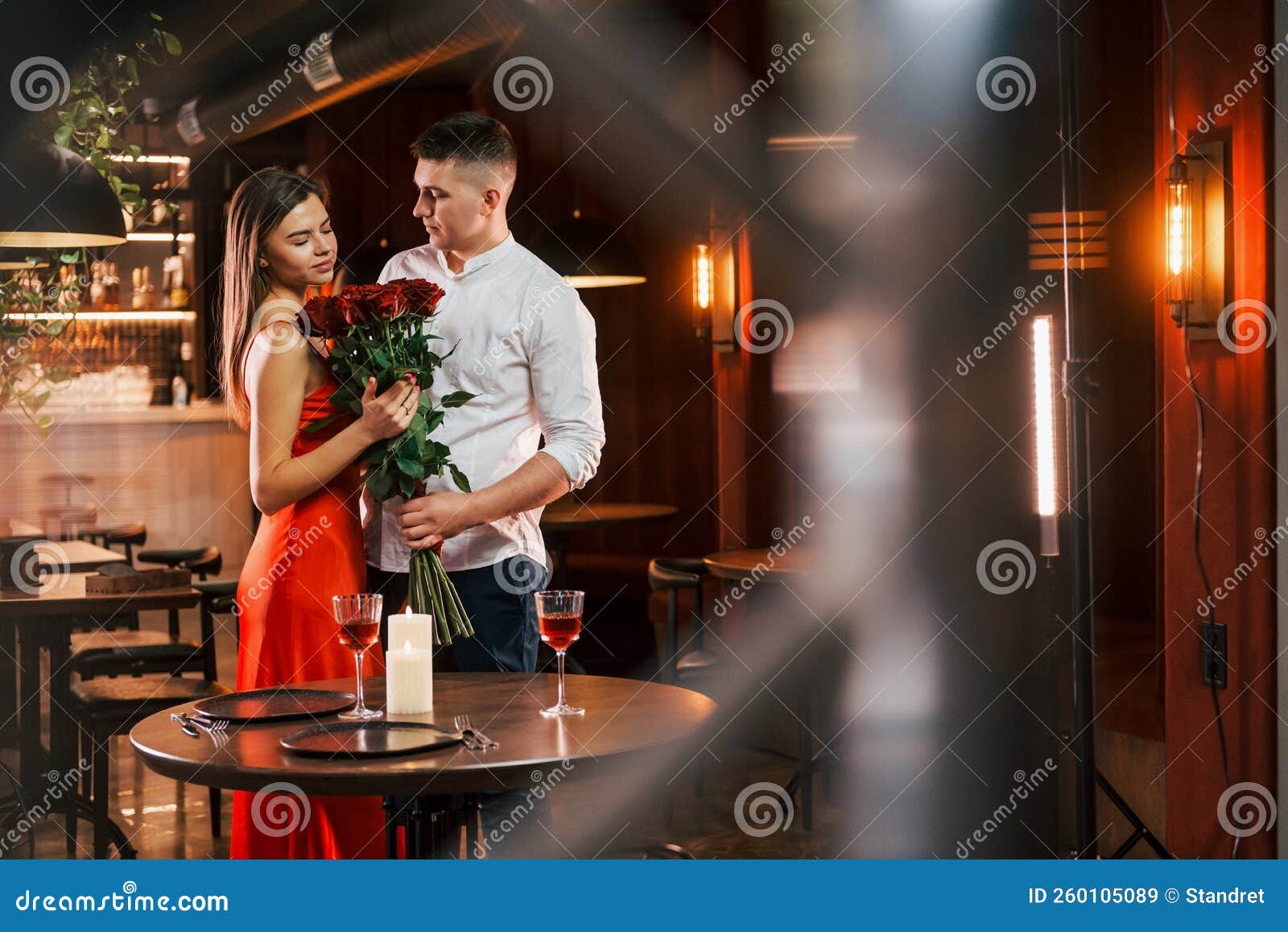 Standing with Flowers. Romantic Couple Have Dinner in the Restaurant ...