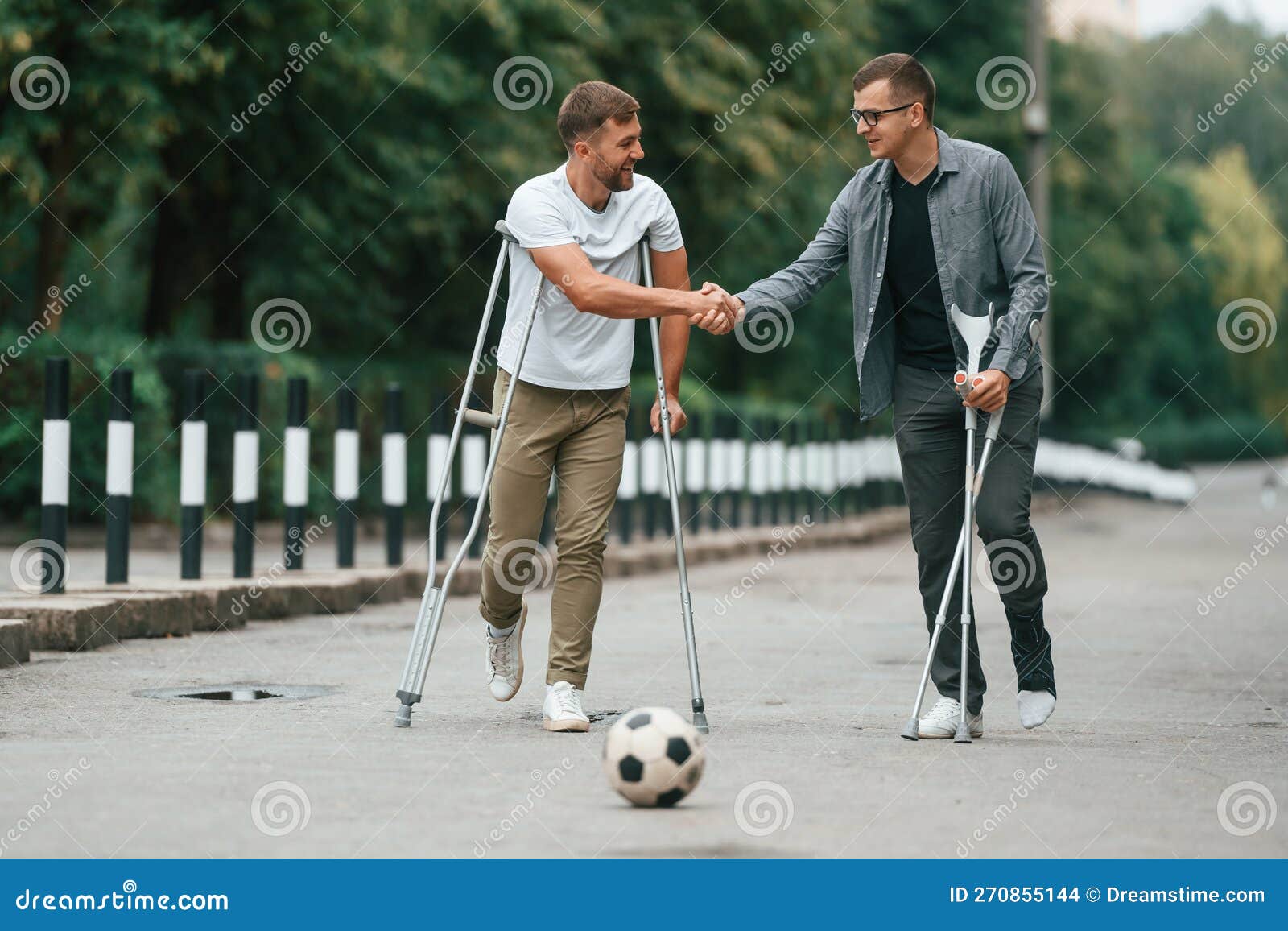 Standing, Having Fun, Playing Soccer. Two Men with Crutches is Outdoors ...