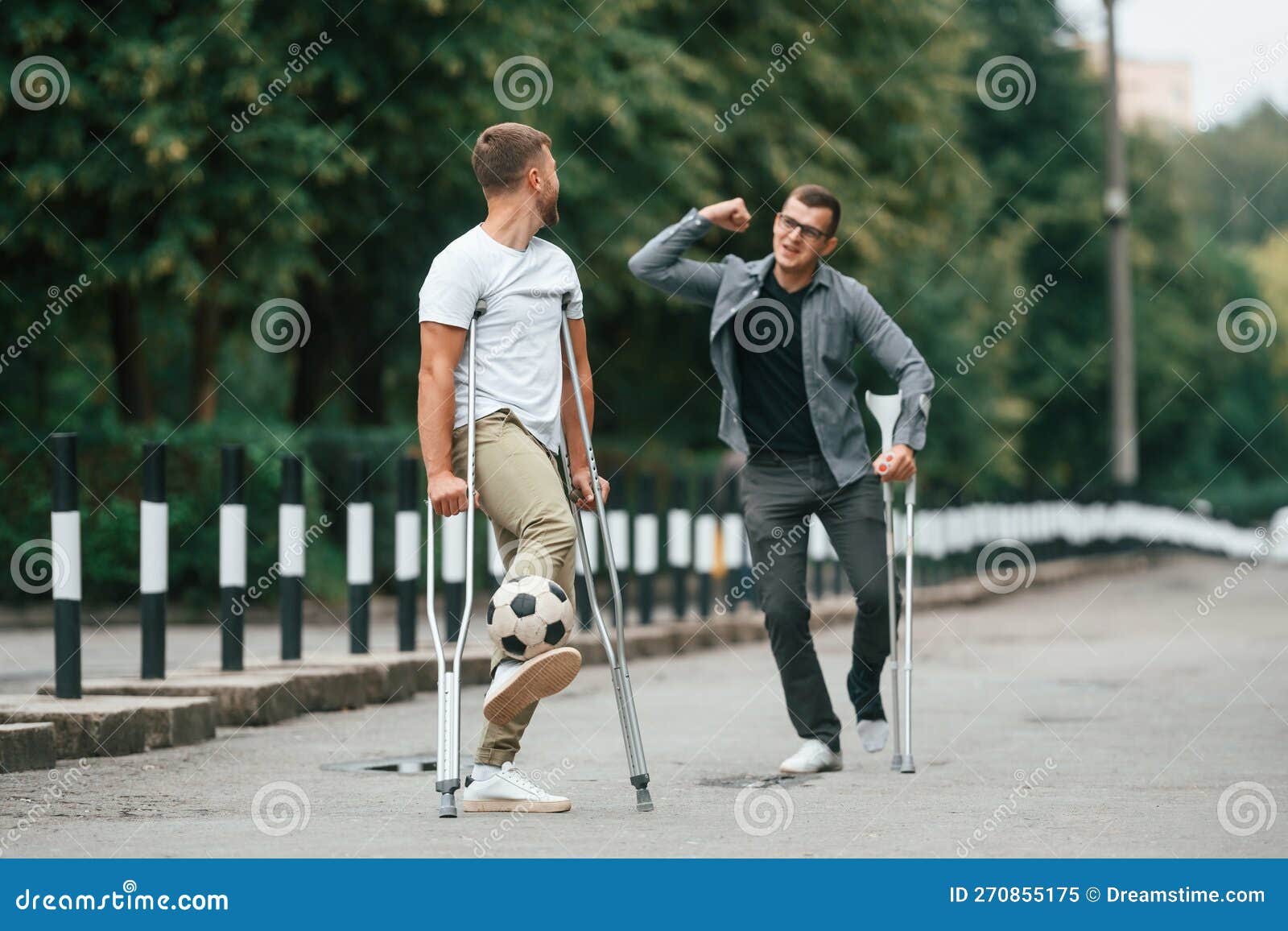 Standing, Having Fun, Playing Soccer. Two Men with Crutches is Outdoors ...
