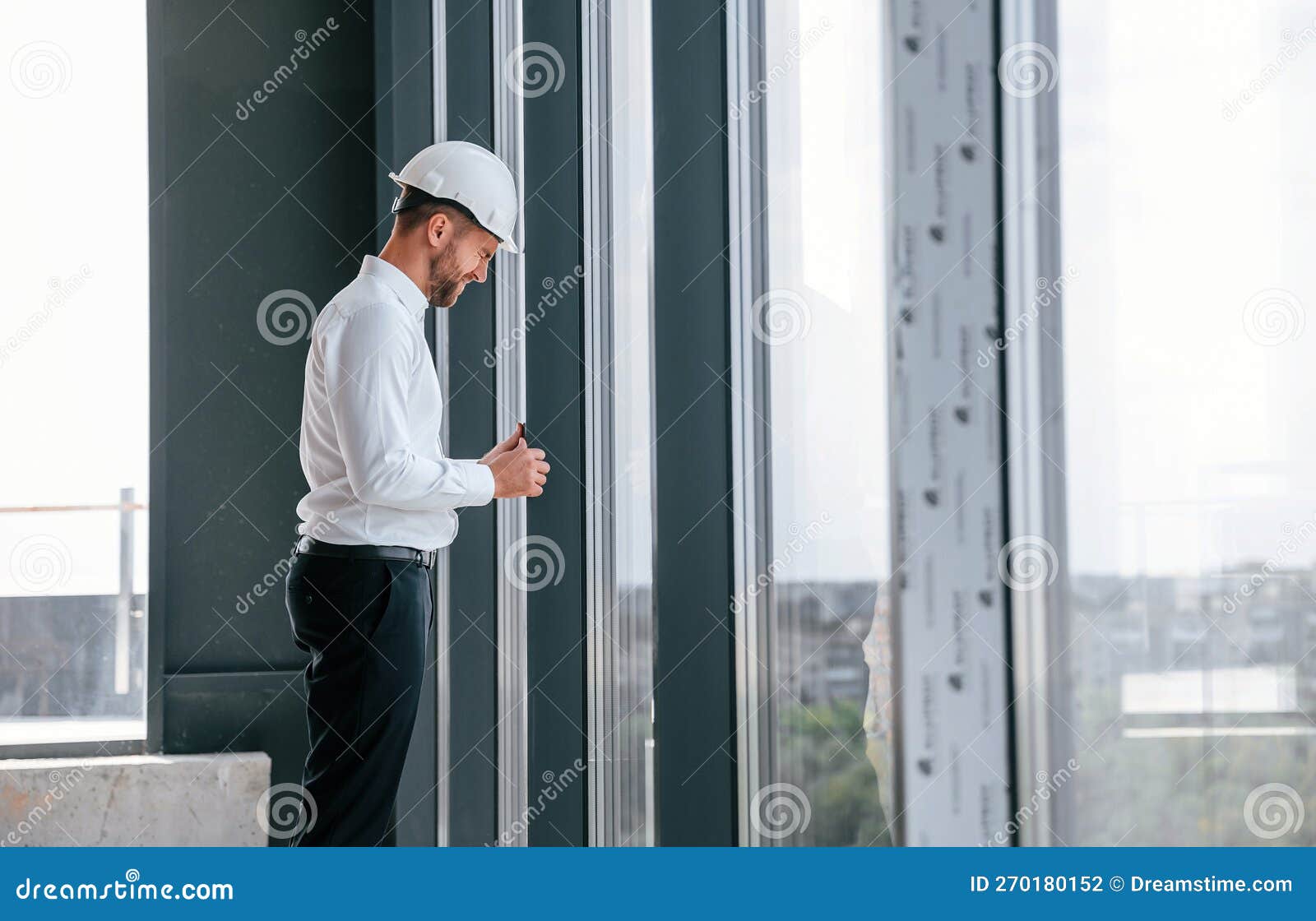 Standing Near Panoramic Windows. Man in White Shirt is Working Indoors ...