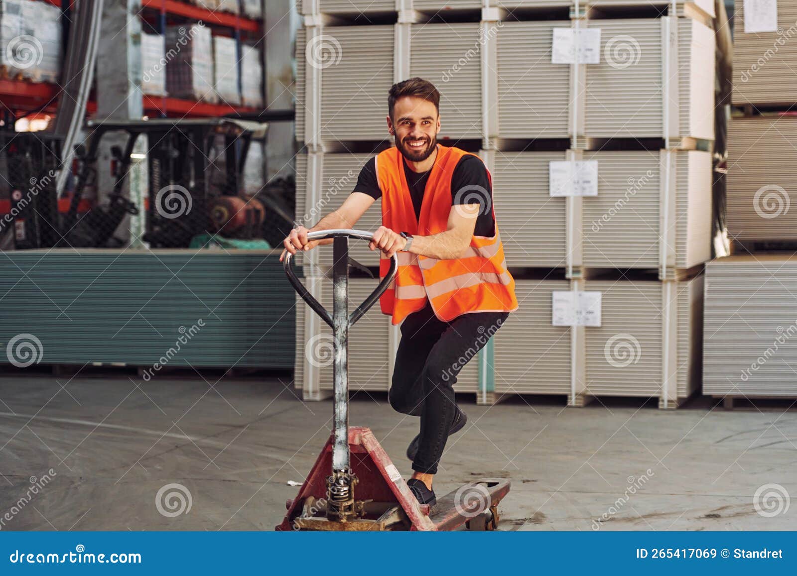 Standing with Platform Trolley. Storage Worker is in the Warehouse with ...