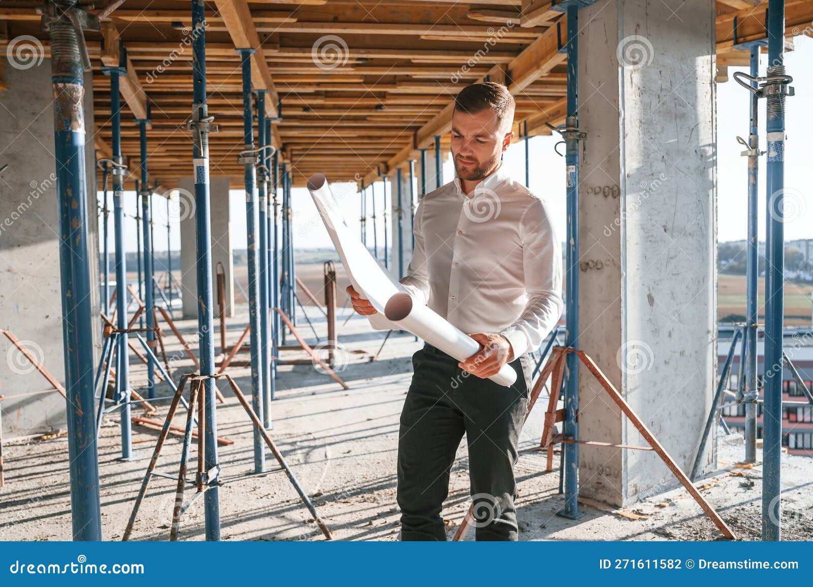 Standing and Reading Plan. Man is Working on the Construction Site at ...