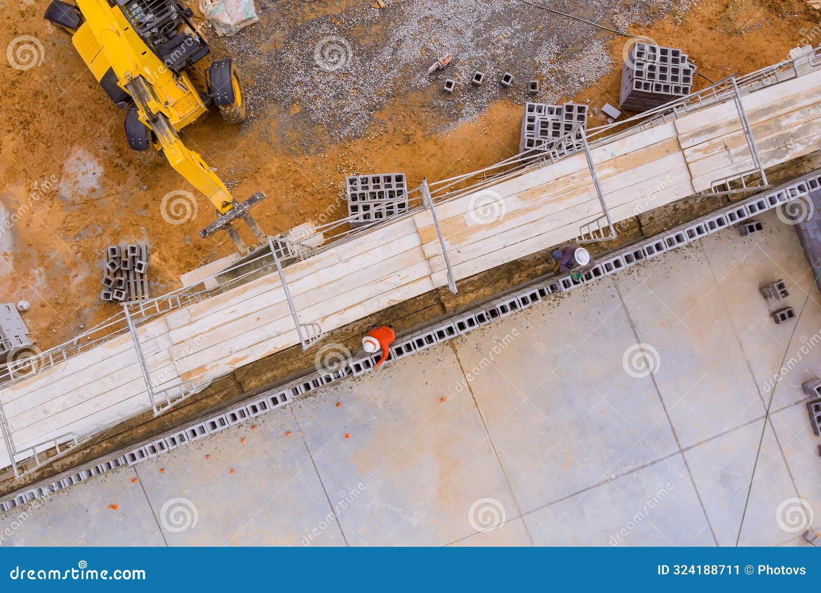 Standing on Scaffold, Bricklayer Constructs a Working Concrete Wall ...