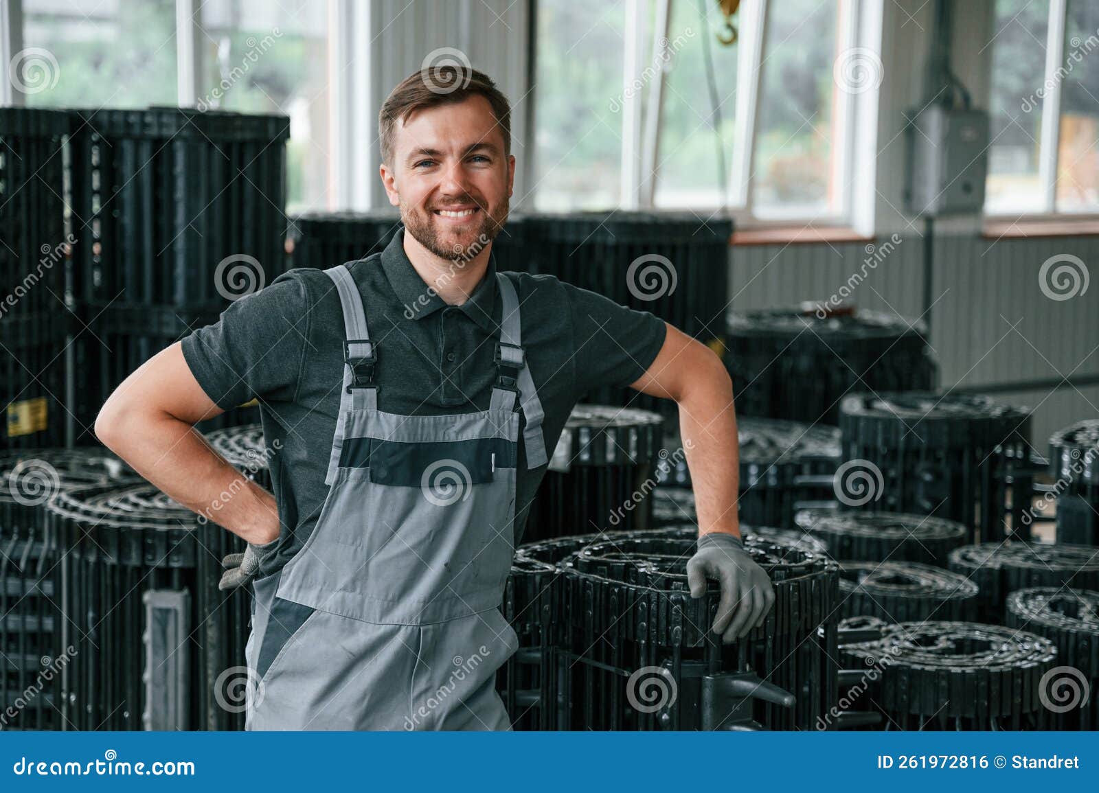 Standing and Smiling. Man in Uniform is in Workstation Developing ...