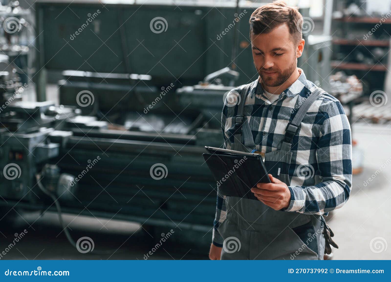 Standing and Using Graphic Tablet. Factory Male Worker in Uniform is ...