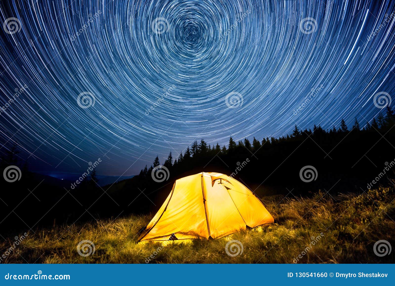 Star Circles Above the Night Mountain Forest and a Glowing Camping Tent ...