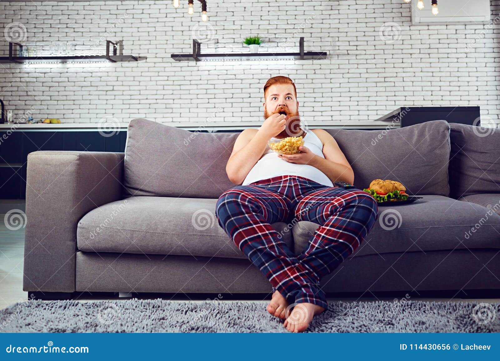 Starker Lustiger Mann in Den Pyjamas Einen Burger Essend, Der Auf Der ...