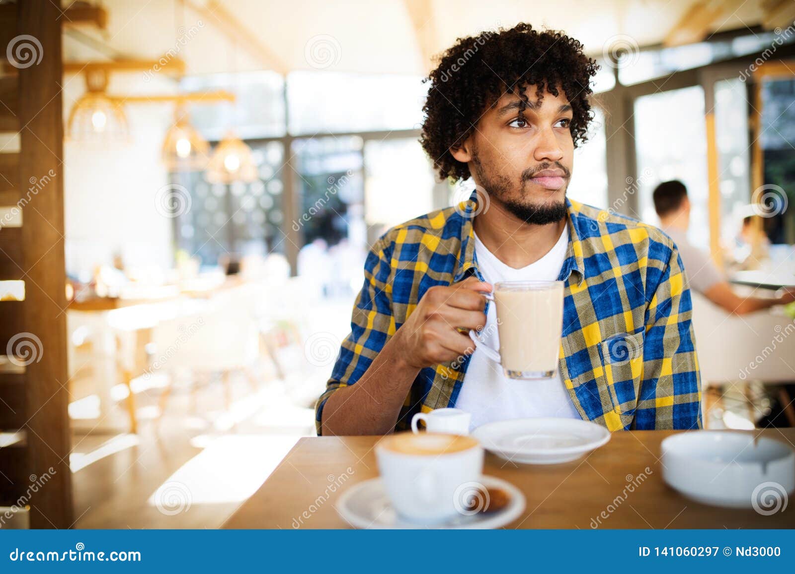 Starting New Day in Cafe. Side View of Young African Man Holding Coffee ... Starting New Day in Cafe. Side View of Young African Man Holding Coffee ...