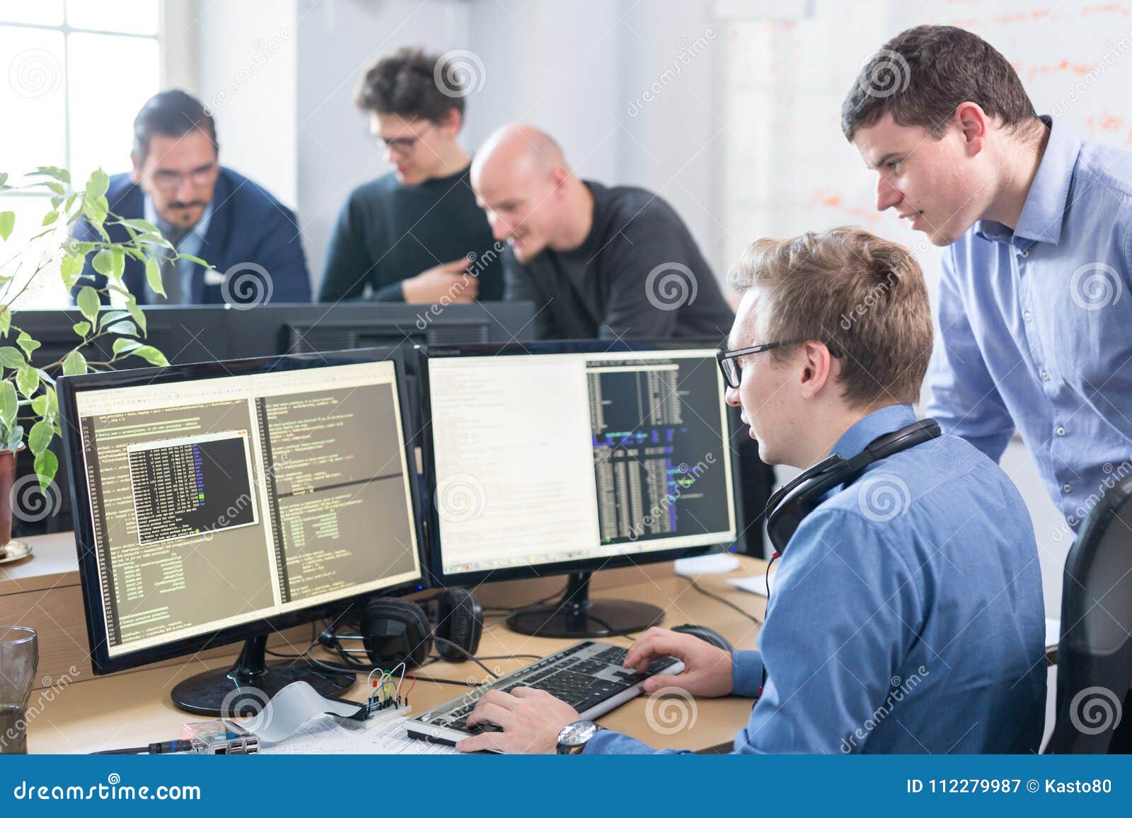 Two Software Developers Are Using Computers To Work Together With Their ...