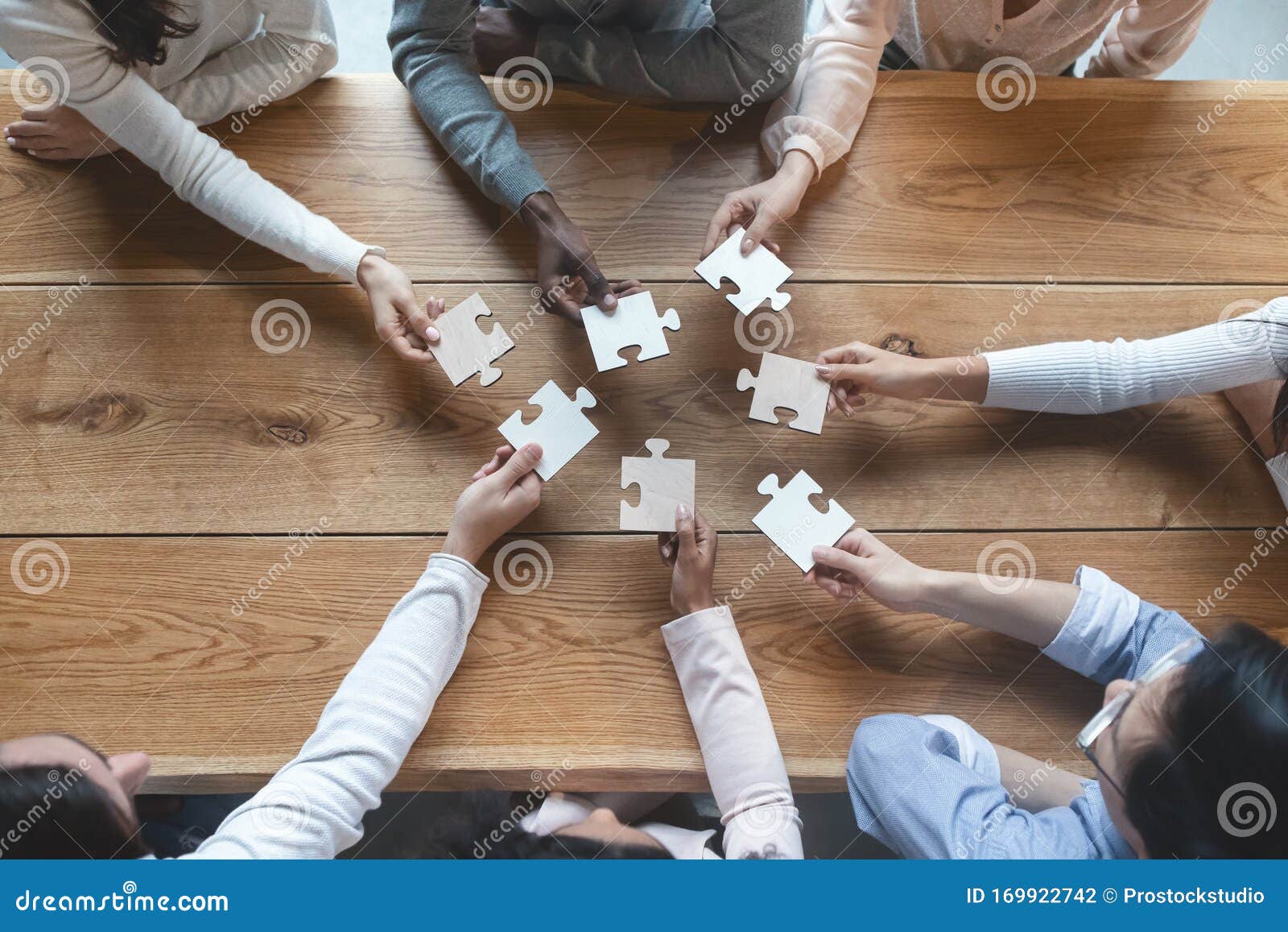 Creative Team Sitting at Table and Putting Together Puzzle Pieces Stock ...