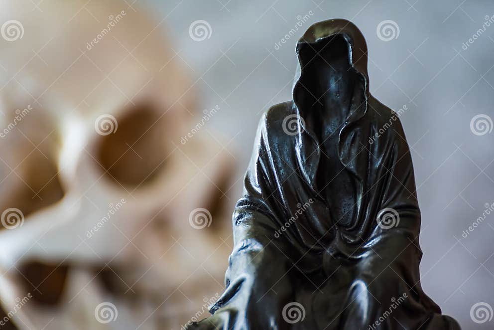 A Statue of a Grim Reaper Sitting and Skull Background Stock Image ...