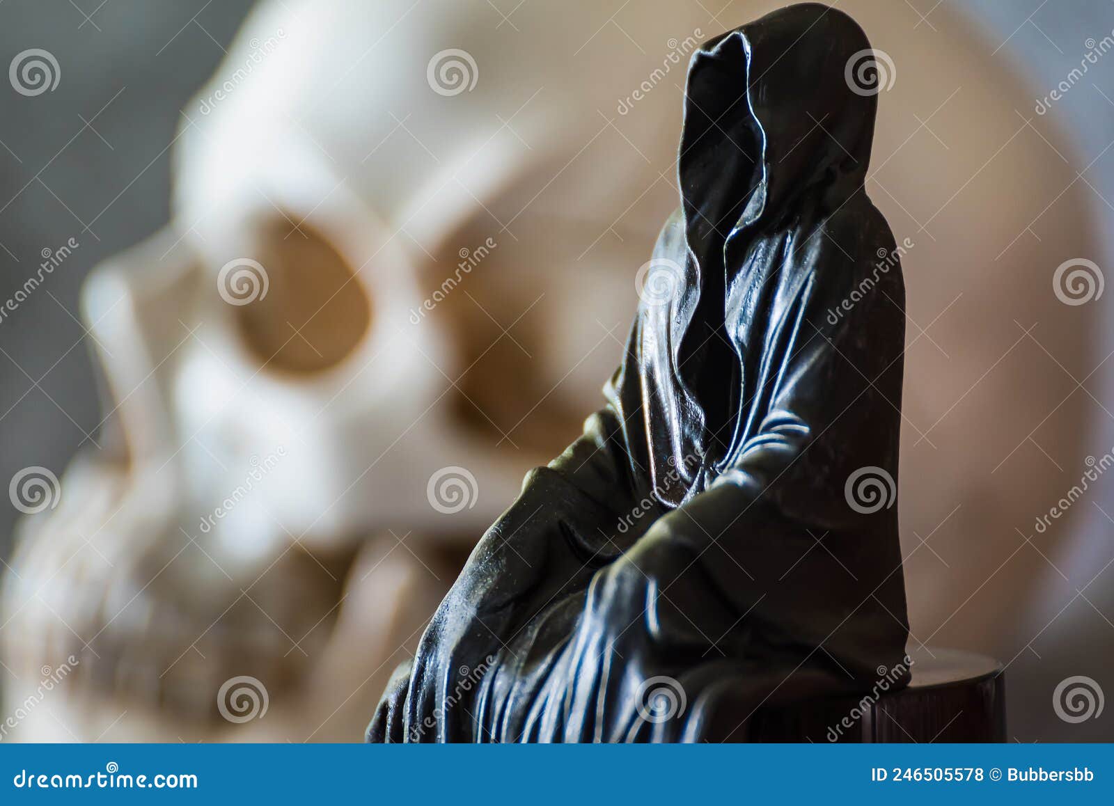 A Statue of a Grim Reaper Sitting and Skull Background Stock Photo ...