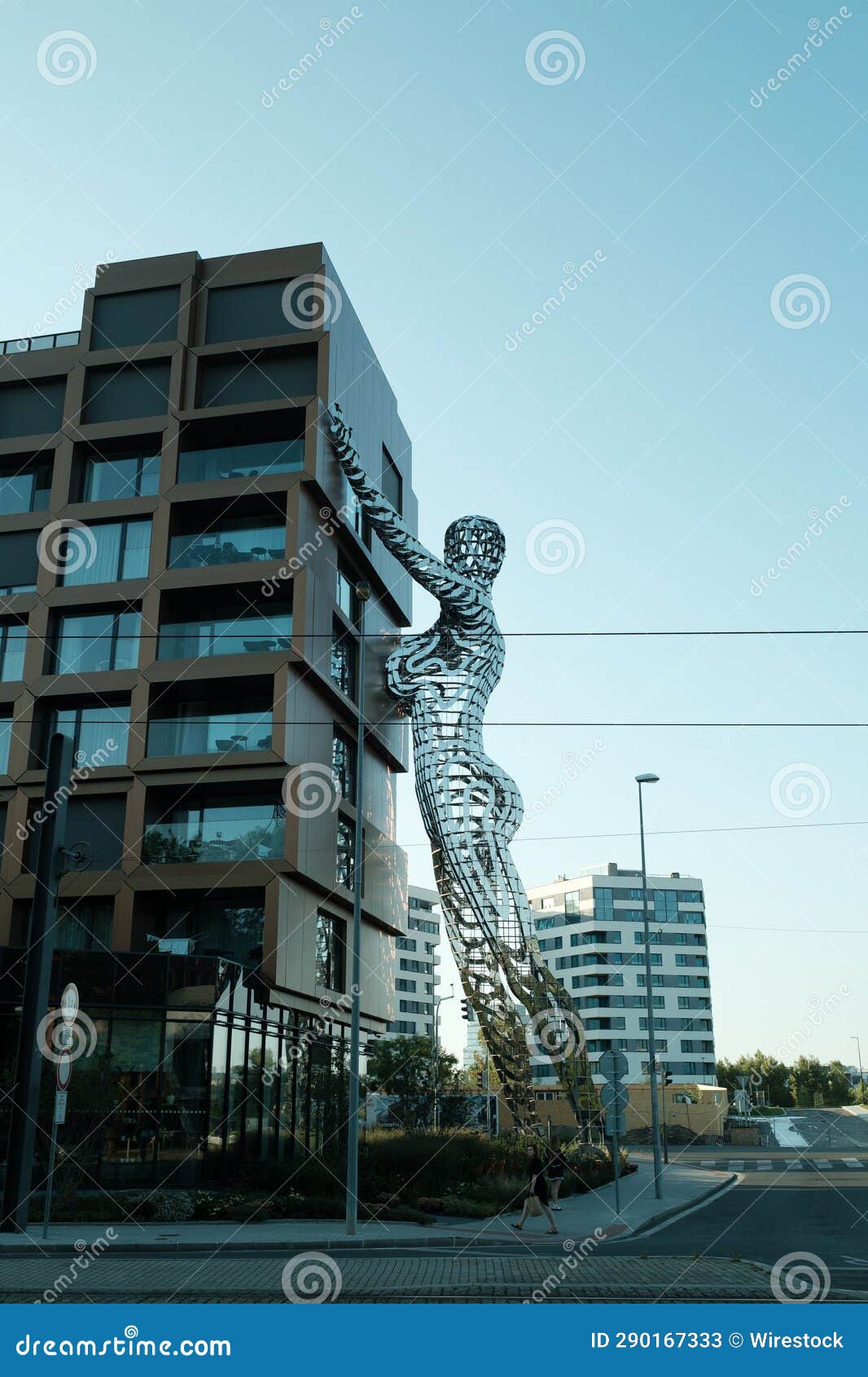 Statue of a Man Ascending a Building, Reaching Towards the Top ...