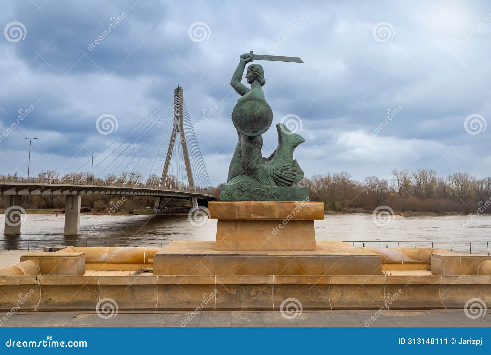 A Statue of a Mermaid with a Sword Against the Background of a Bridge ...