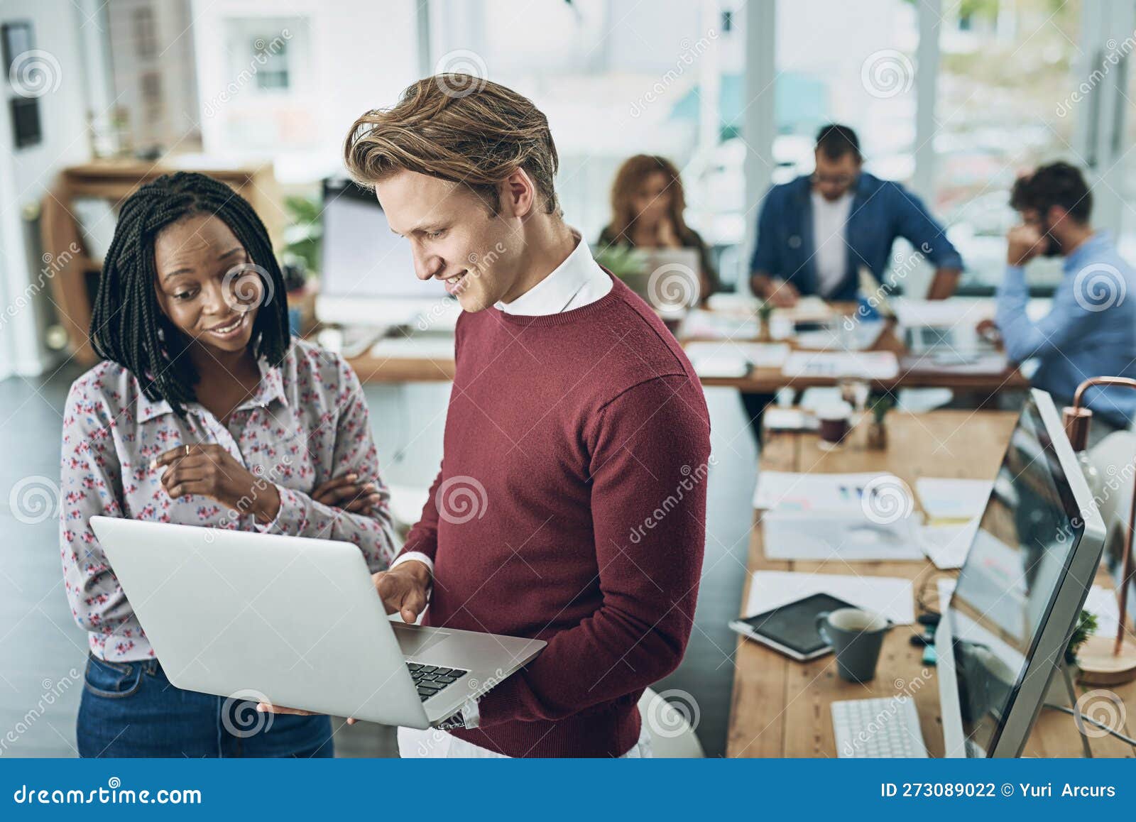 Staying on Track with Teamwork and Tech. Two Young Colleagues Using a ...