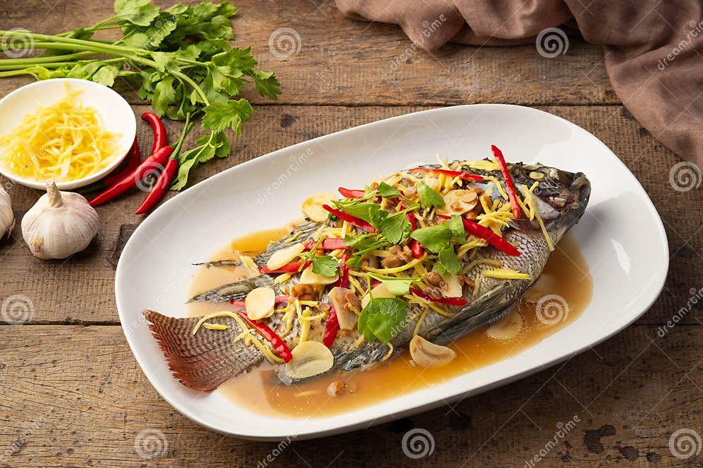 Steamed Tilapia Fish with Soybean Paste Sauce in White Plate Stock ...