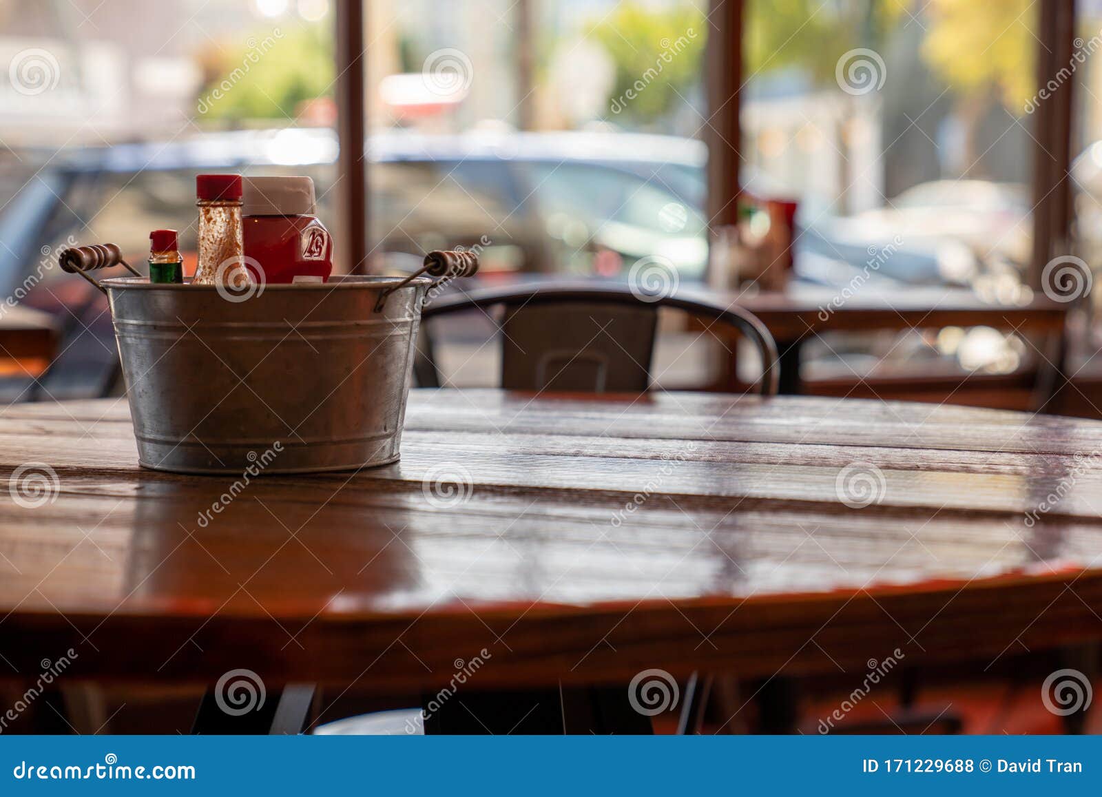 Steel Bucket of Condiments and Sauces on Restaurant Table Stock Photo ...