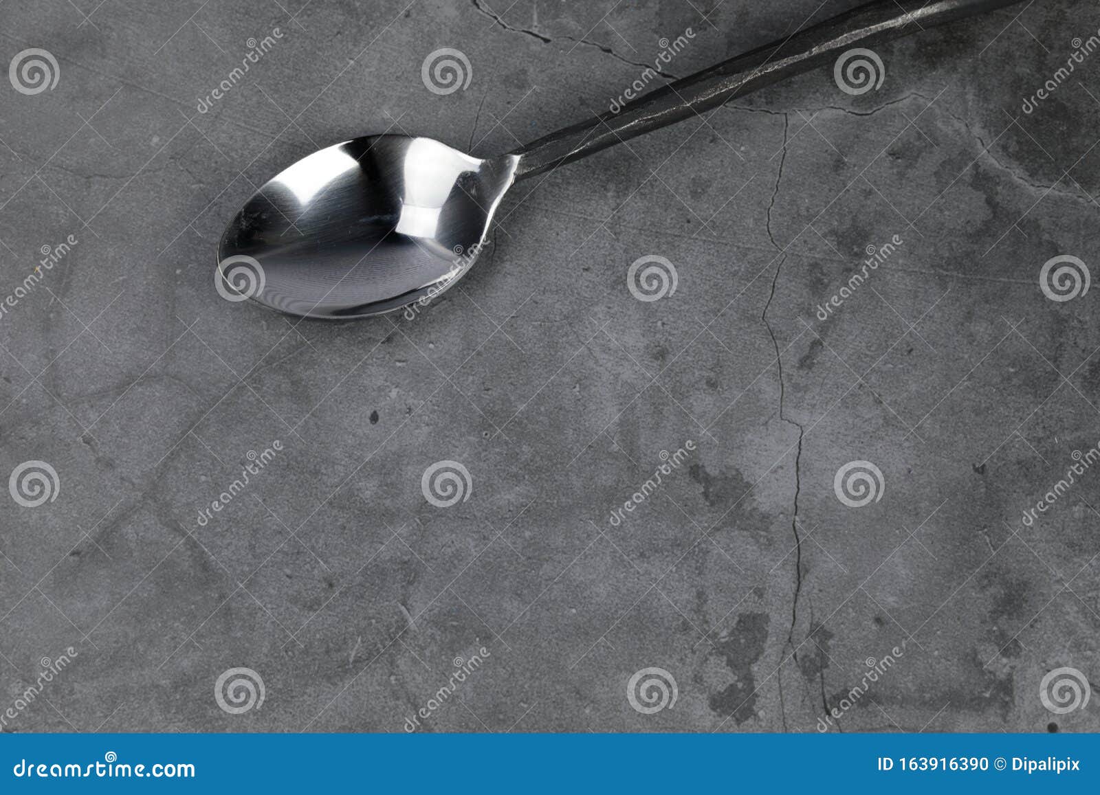 A Steel and Iron Spoon on a Grey Concrete Background Stock Photo ...