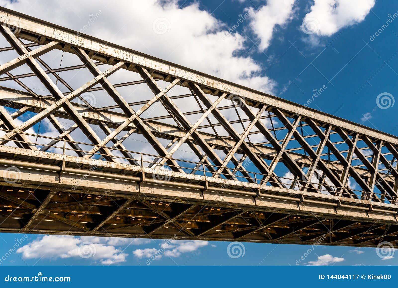 Steel Lattice Construction Of A Railway Bridge On A Background Of Blue