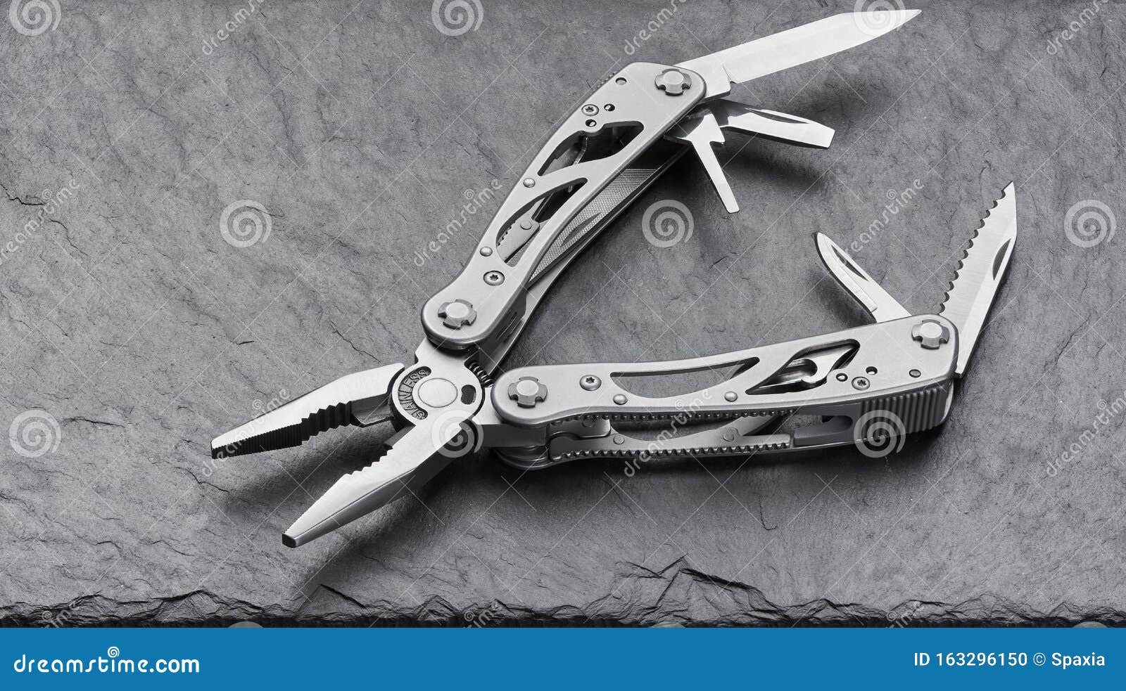 Steel multitool on a stone stock photo. Image of construction - 163296150