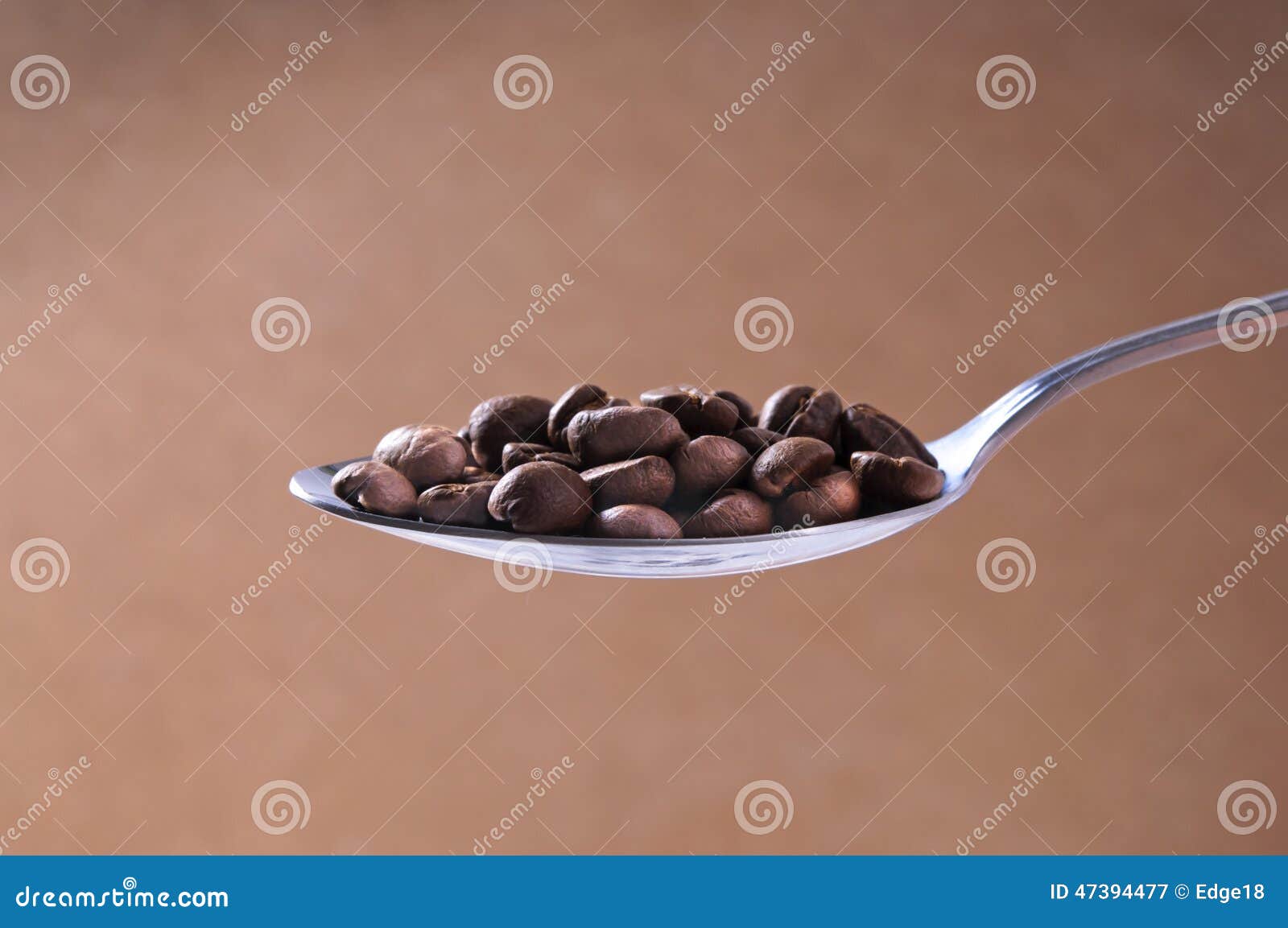 Steel Spoon of Roasted Coffee Beans on Light Brown Stock Image - Image ...