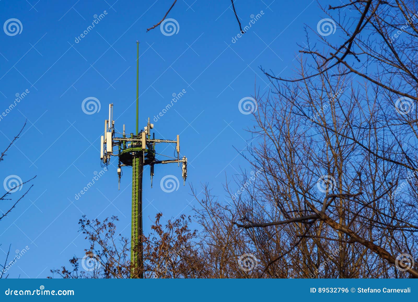 Steel Telecommunication Tower with Antennas Over Blue Sky and Trees ...