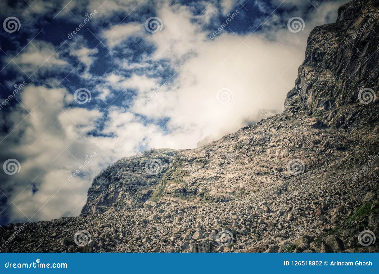 Steep Cliff Drop from a Mountain with Deep Blue Sky and Clouds Stock ...