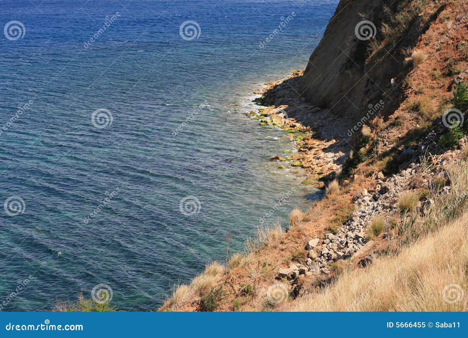 Steep Slope Of Rock Falling Stones With Lava Cliffs And Blue Sea ...