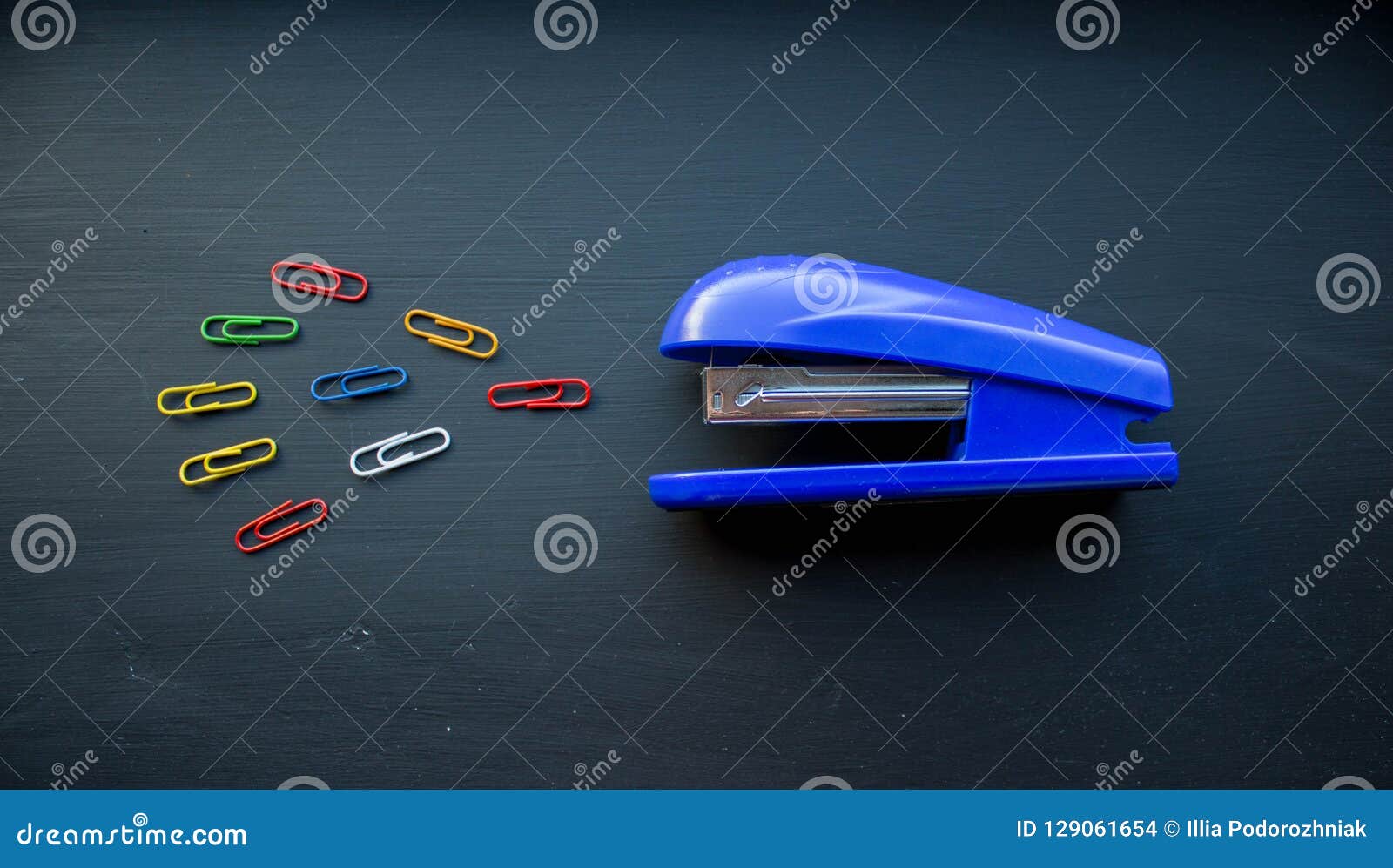 A Stepler and Colored Clips on Black Background Stock Photo - Image of ...