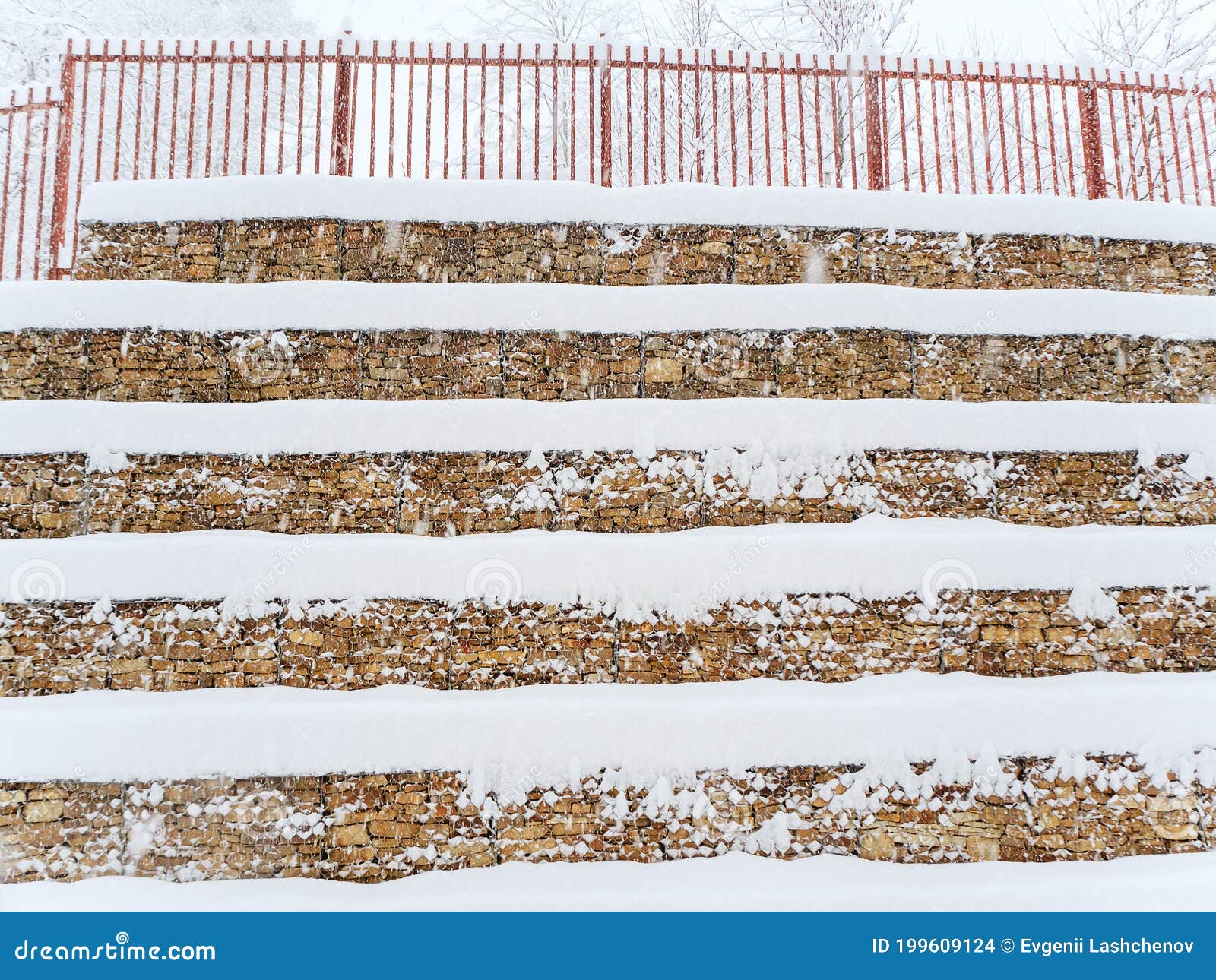 Stepped Wall Made of Stones Fixed with a Grid with a Fence at the Top ...