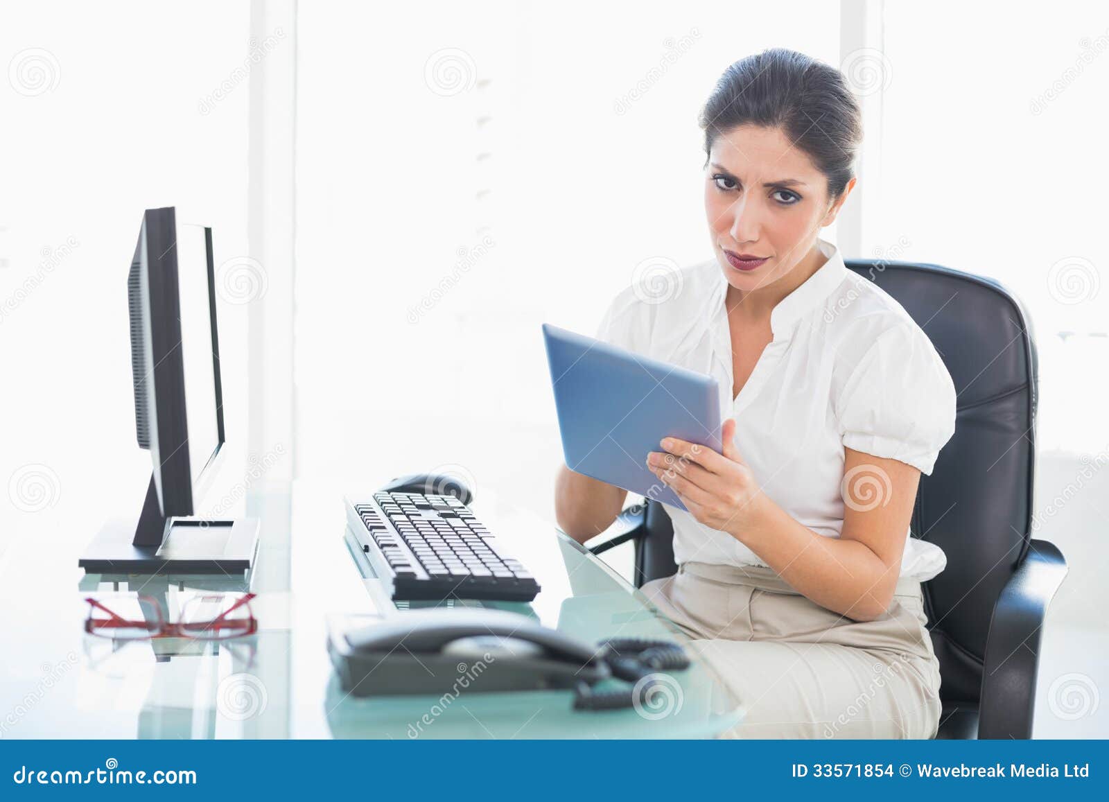 Stern Businesswoman Using Her Digital Tablet at Desk Stock Photo ...