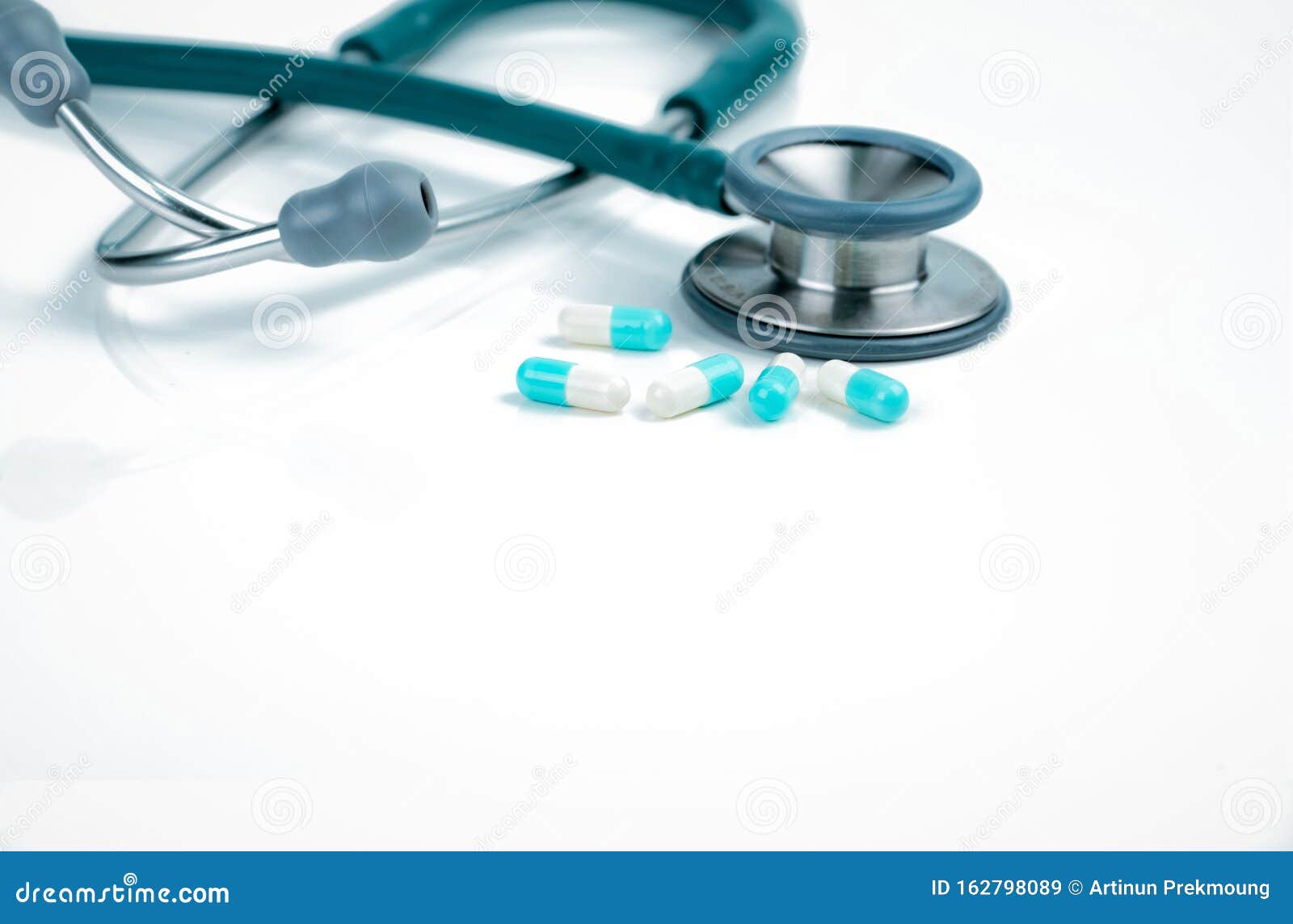 Stethoscope And Blue White Capsule Pills On Doctor Table Or Nurse Desk