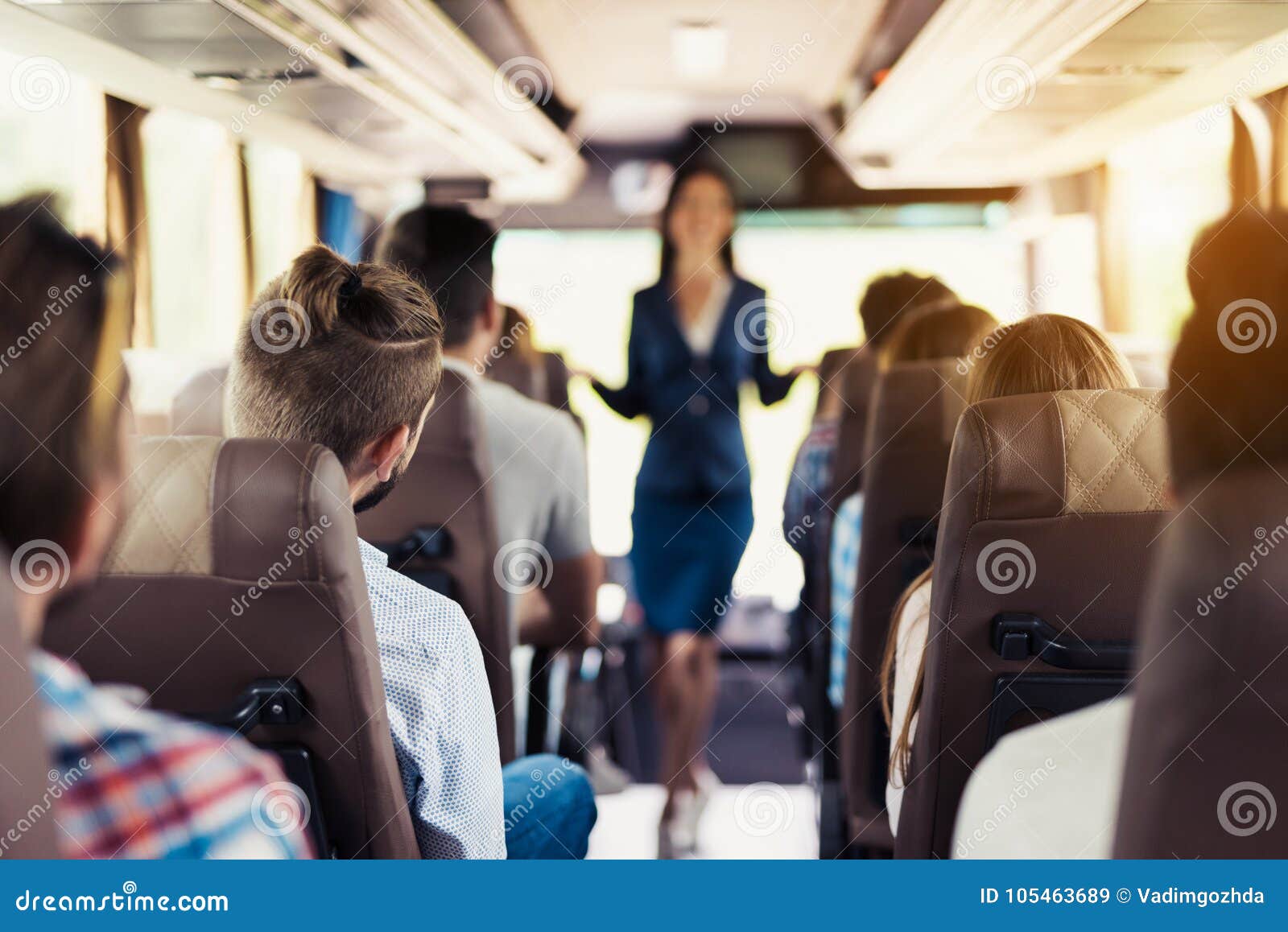 A Stewardess is Posing on the Bus. it Stands between the Rows of Seats ...