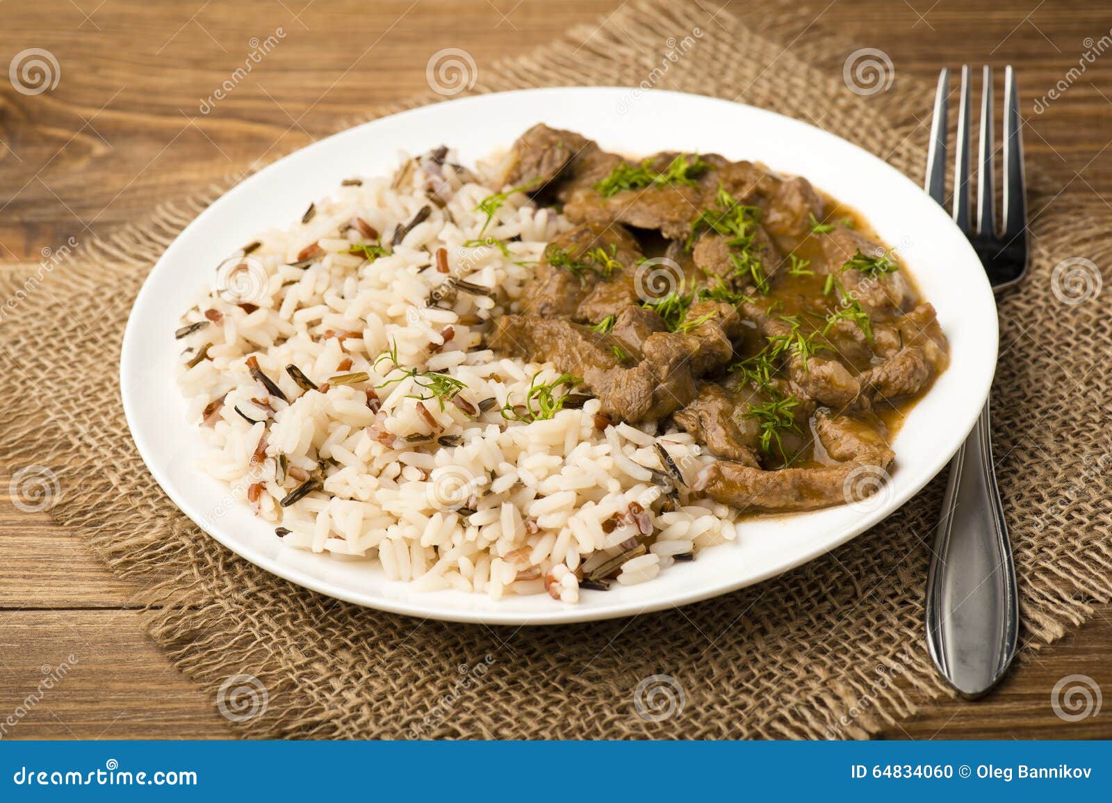 Stewed Beef and Rice on the White Plate on Wooden Background. Stock ...