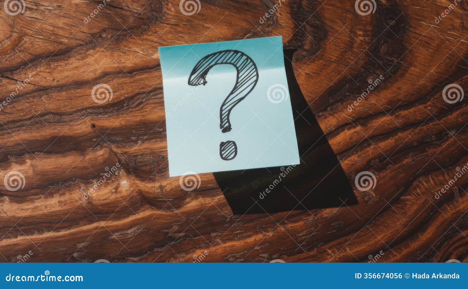 Sticky Note Displaying a Handwritten Question Mark on a Grained Wooden ...