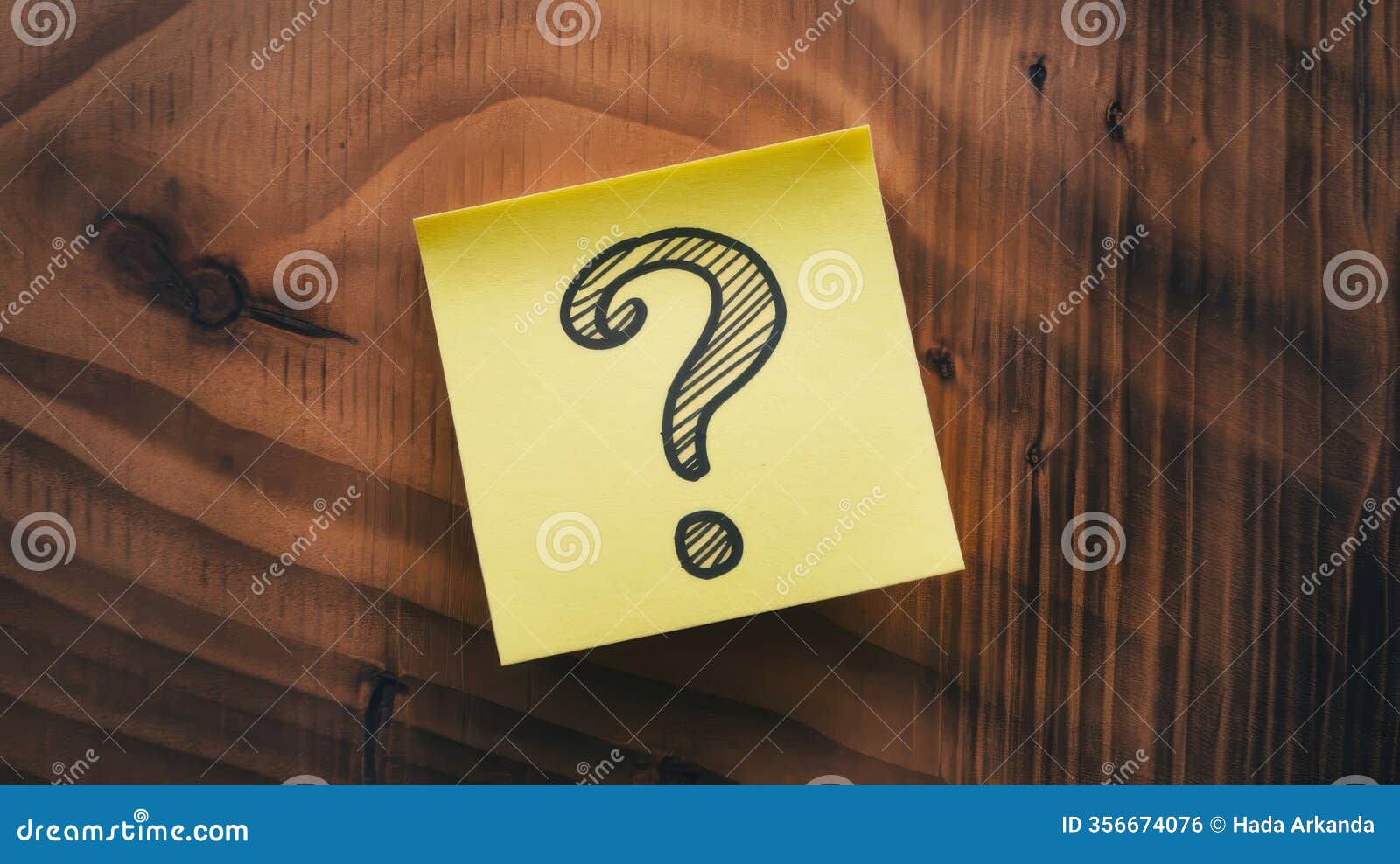 Sticky Note Displaying a Handwritten Question Mark on a Grained Wooden ...