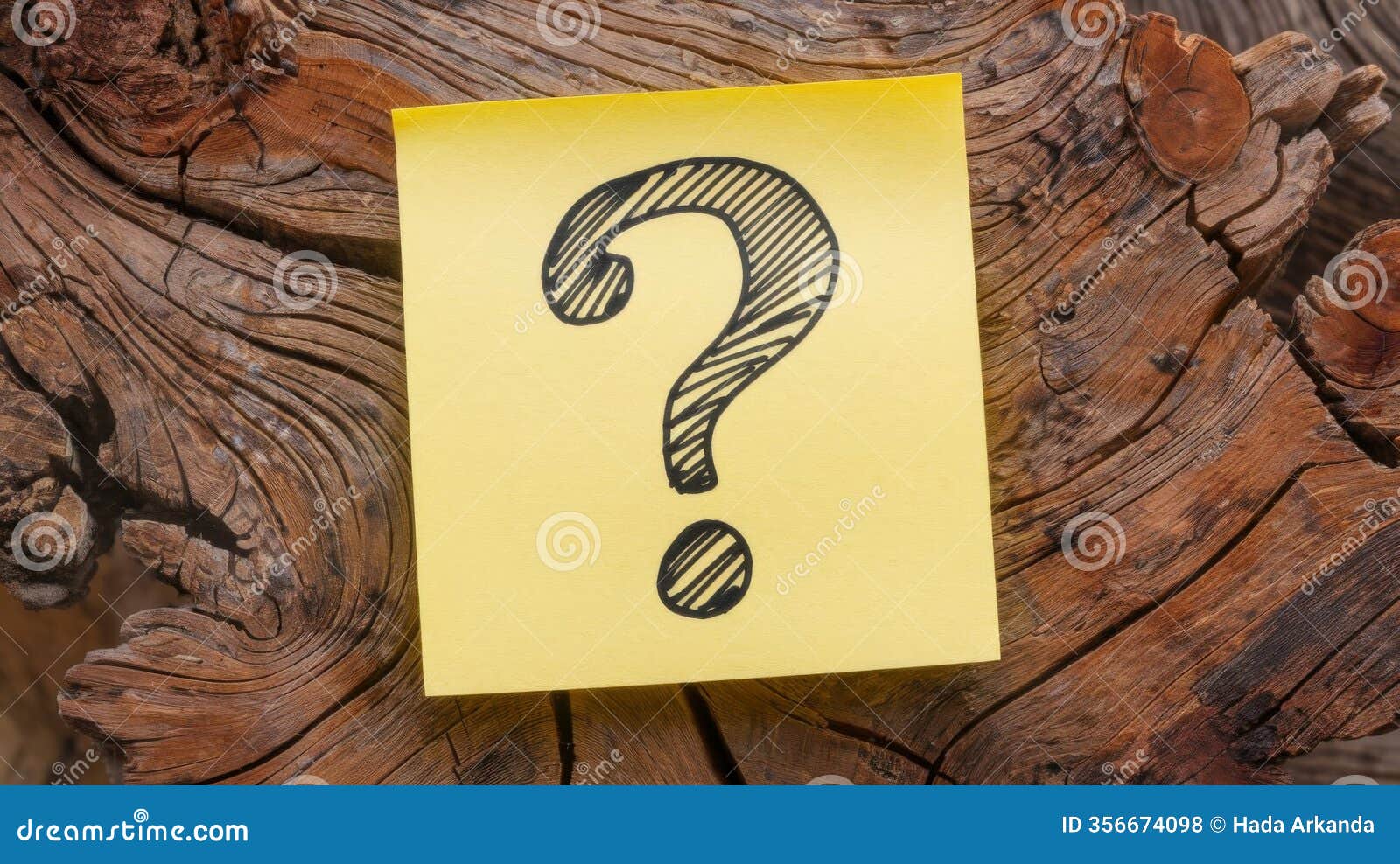 Sticky Note Displaying a Handwritten Question Mark on a Grained Wooden ...