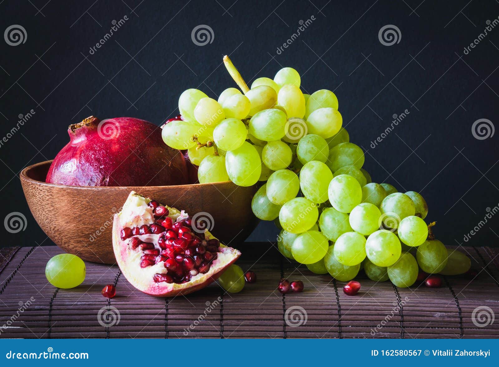 Still Life with Pomegranate and Green Grapes on a Dark Background Stock ...