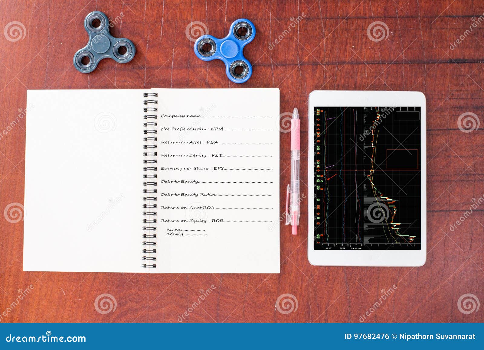 Stock Graph on Tablet, Pen, Hand Spinner, Notebook on Wood Table Stock ...