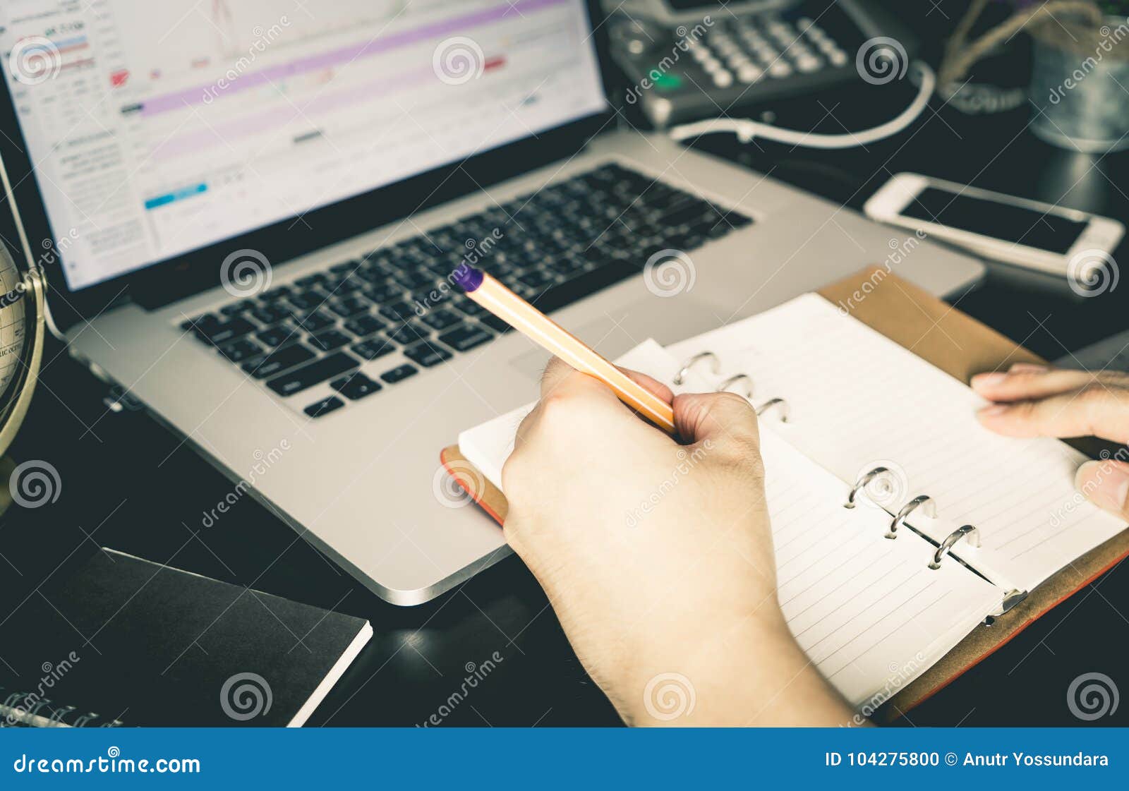Stock Trader is Taking Note on His Notebook and Analyzing on Computer ...