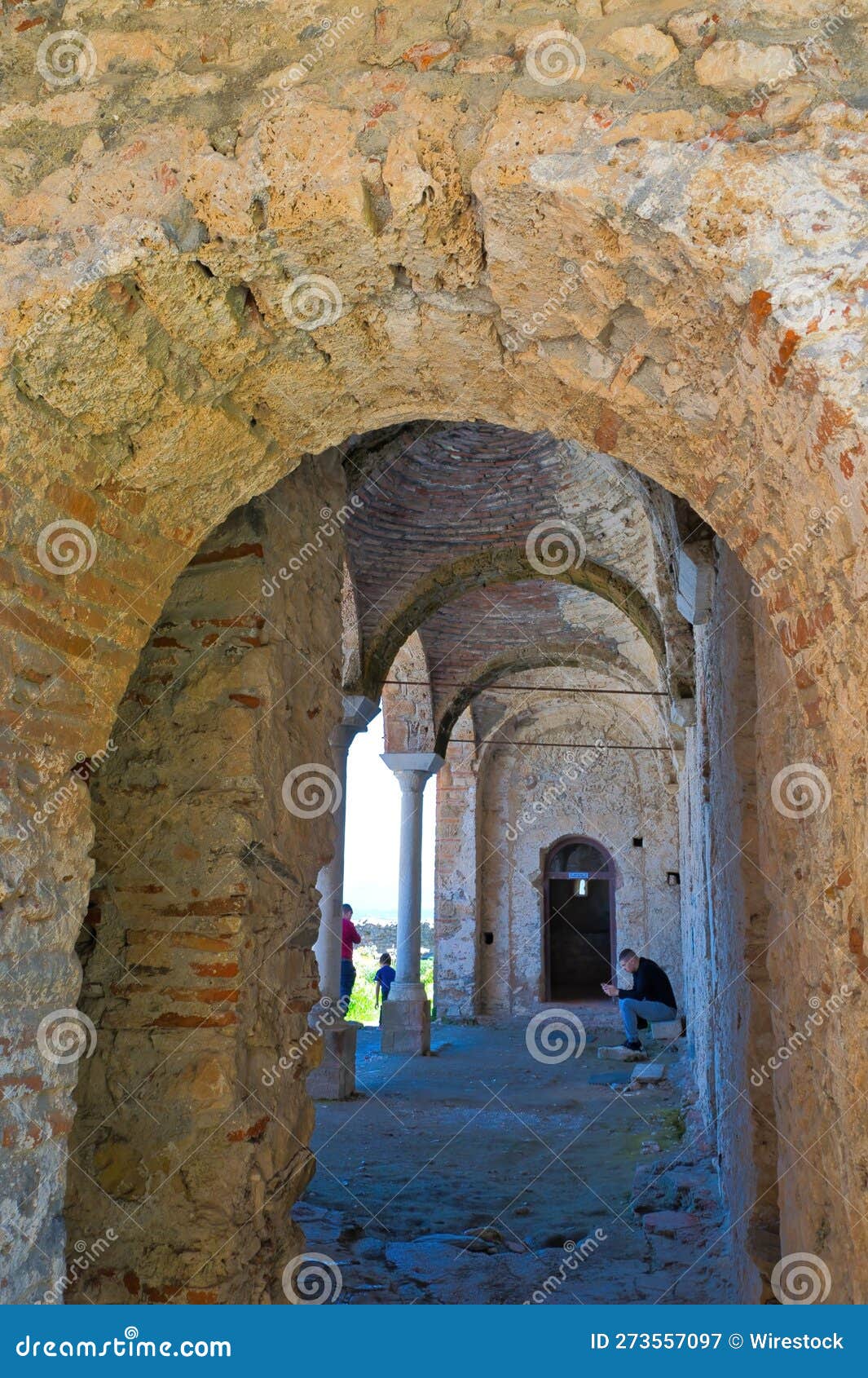 Stone-arched Walkway in an Ancient Building with a Group of Tourists in ...