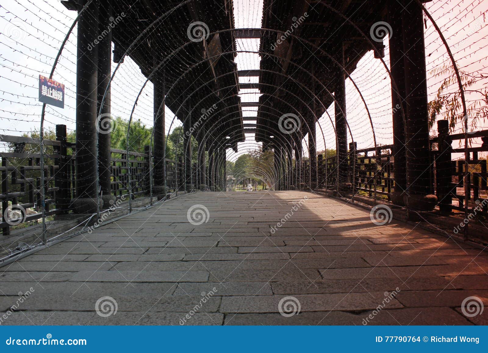 A Stone Bridge with Rain Roof and LED Light Curve Crossing a Small ...